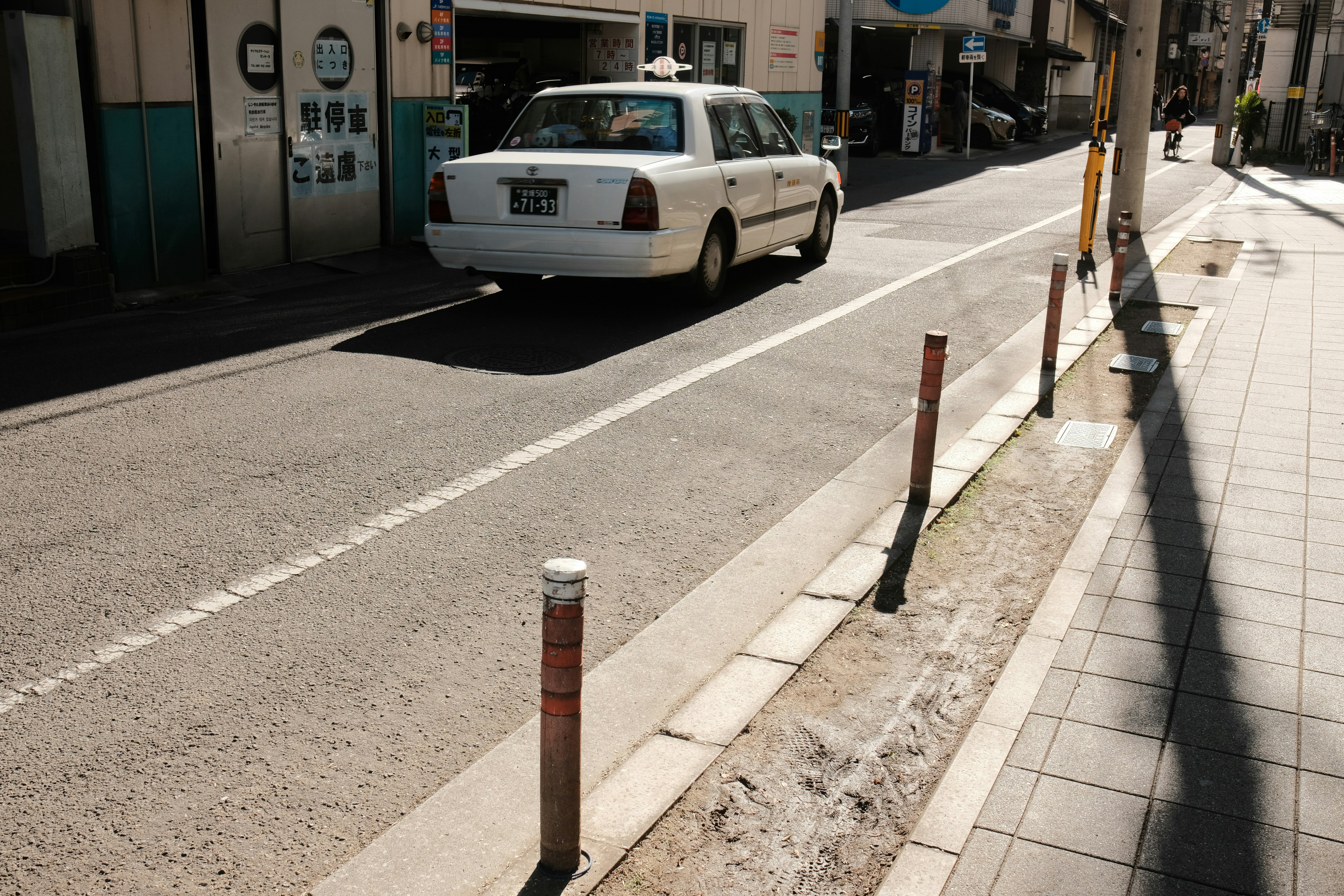 Quiet City Street: White Taxi and Shadowed Sidewalk