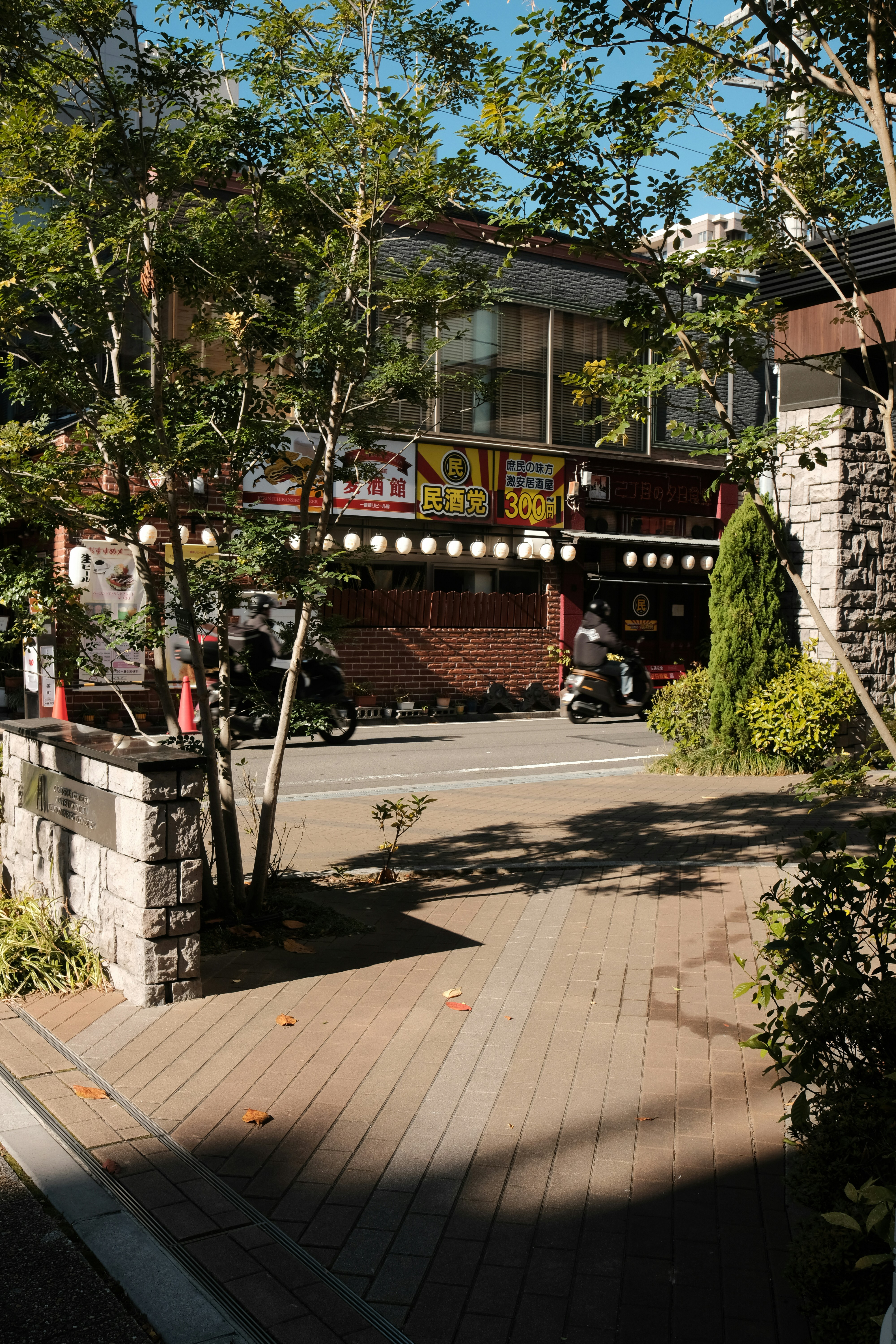 Shaded Courtyard Frame: Alley Facade and Passing Scooters
