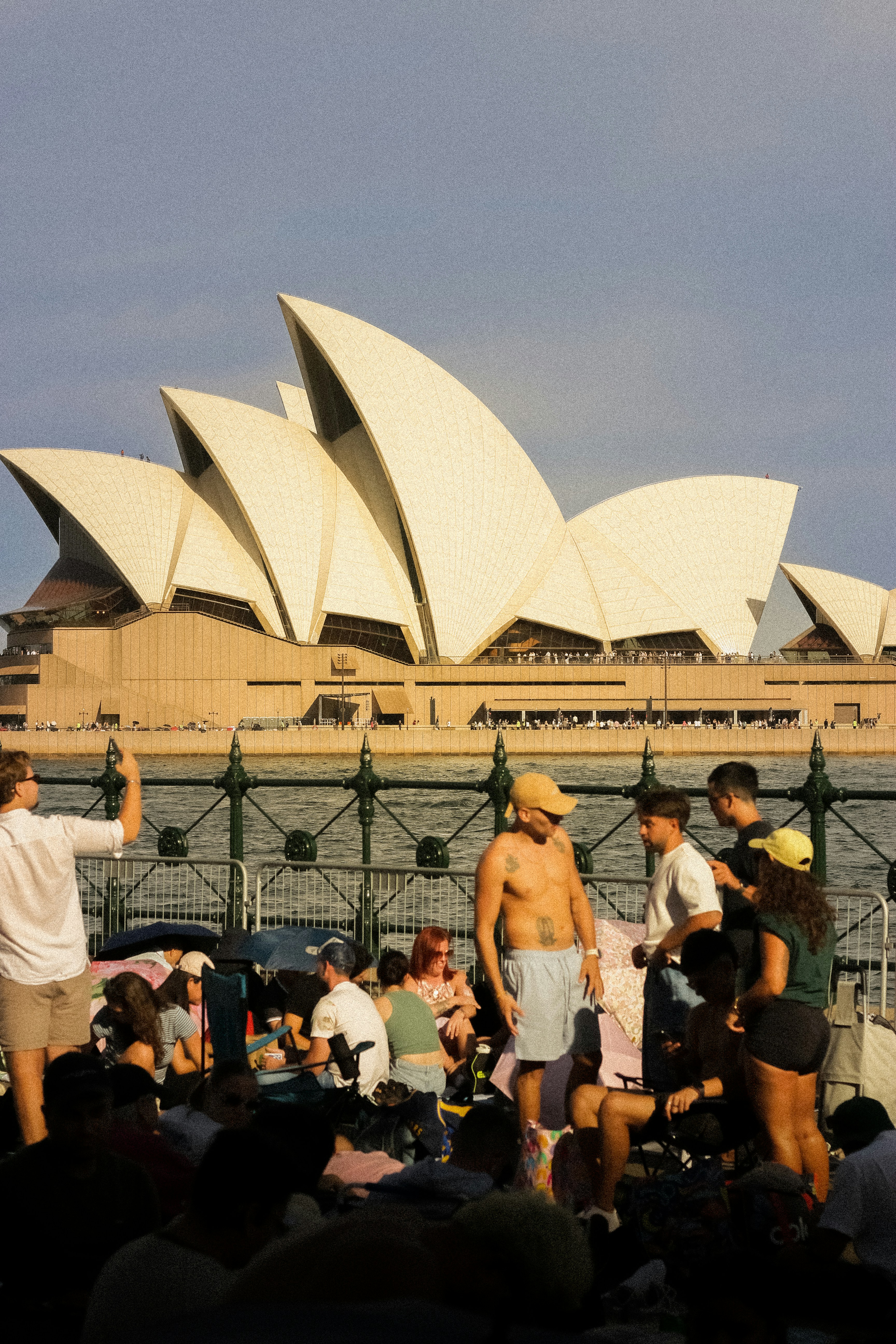 Festival by the Harbour: People Gather as the Opera House Silhouettes Above