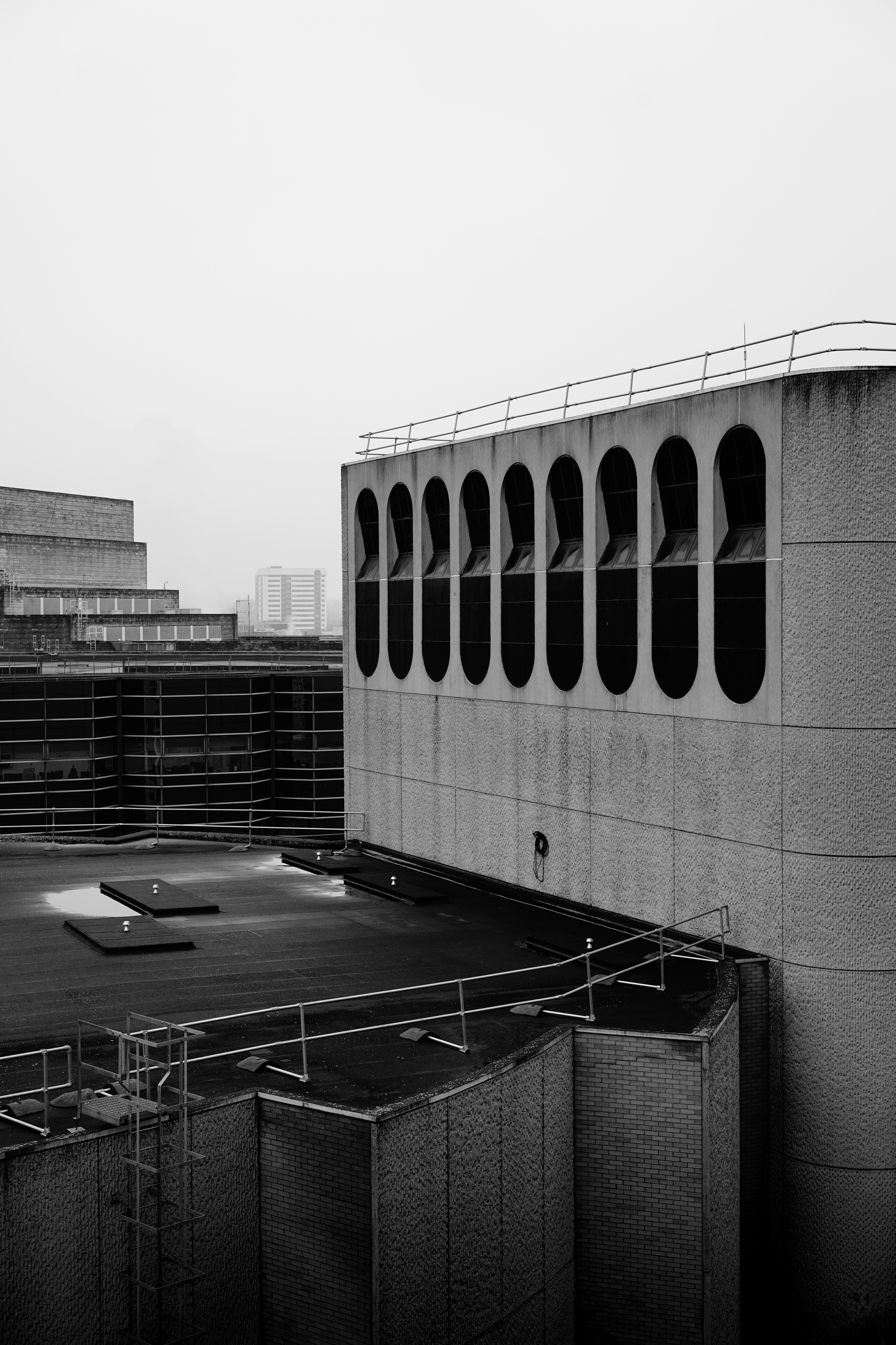 Concrete Echoes: Arched Facade Overlooking a Quiet Rooftop
