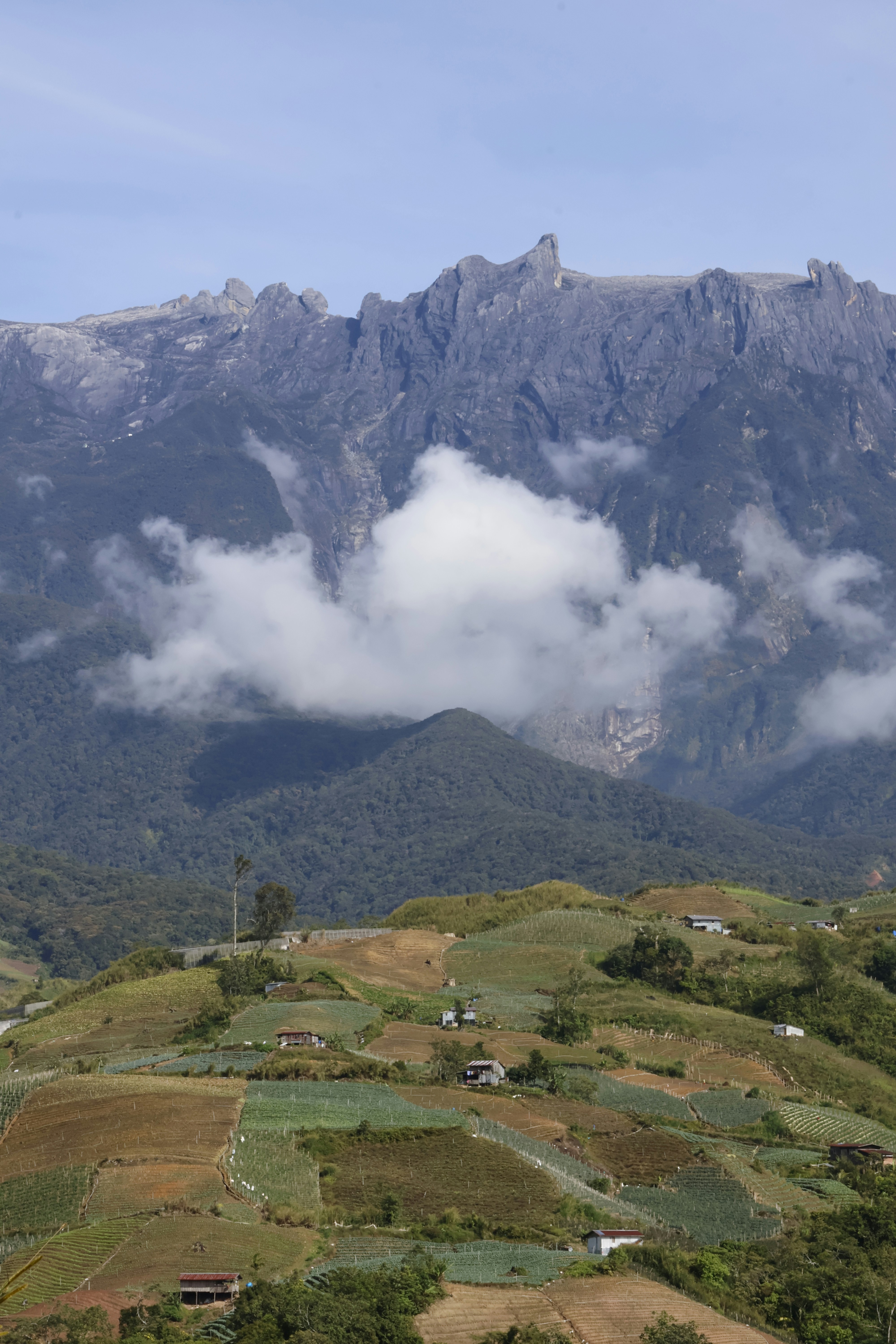 Skyline and Terraced Hills: A Mountain Vista Beneath Floating Clouds