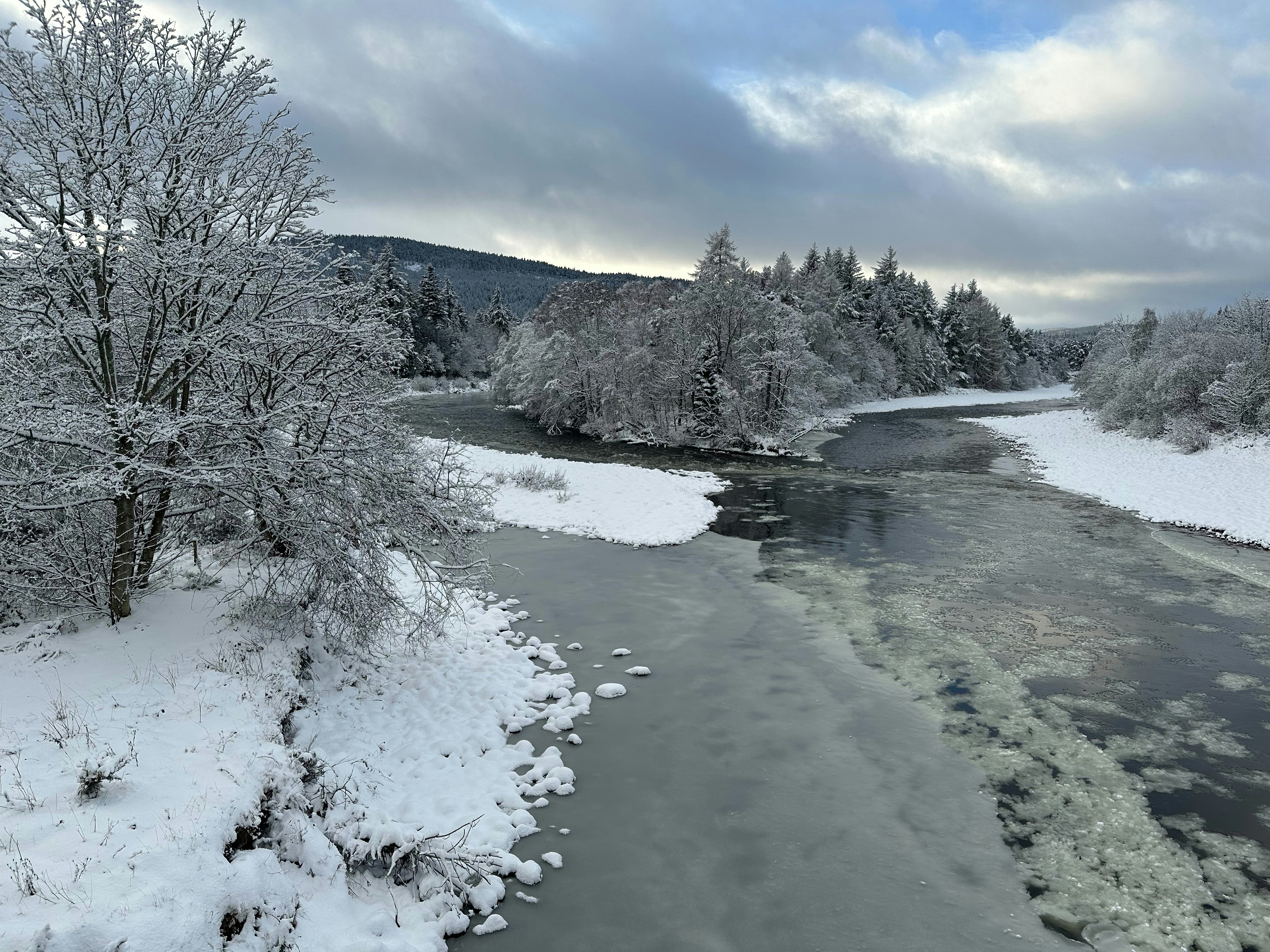Snowbound River Bend Under Cloudy Sky