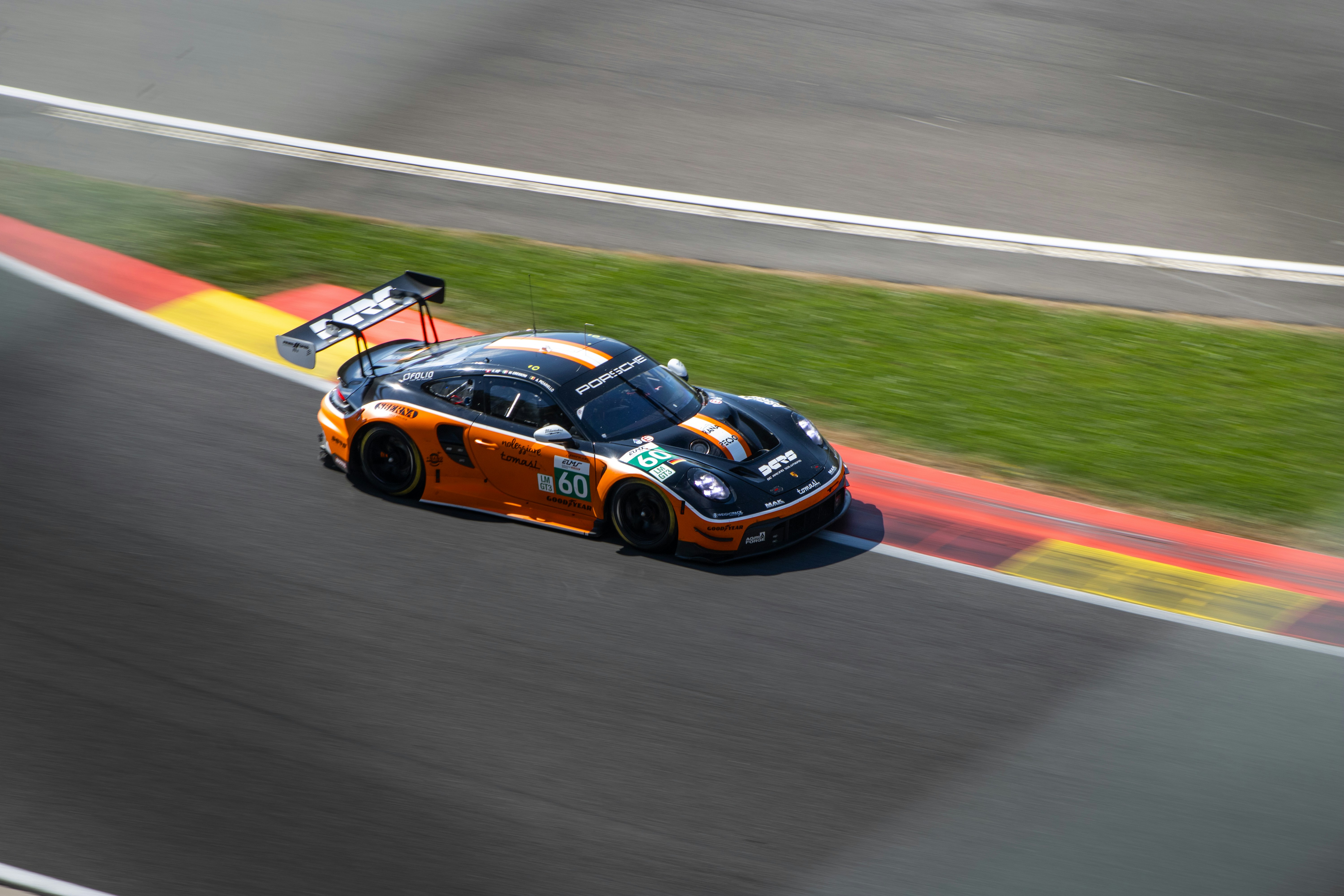 Orange Racer in Sharp Focus, Blurred Track Trail