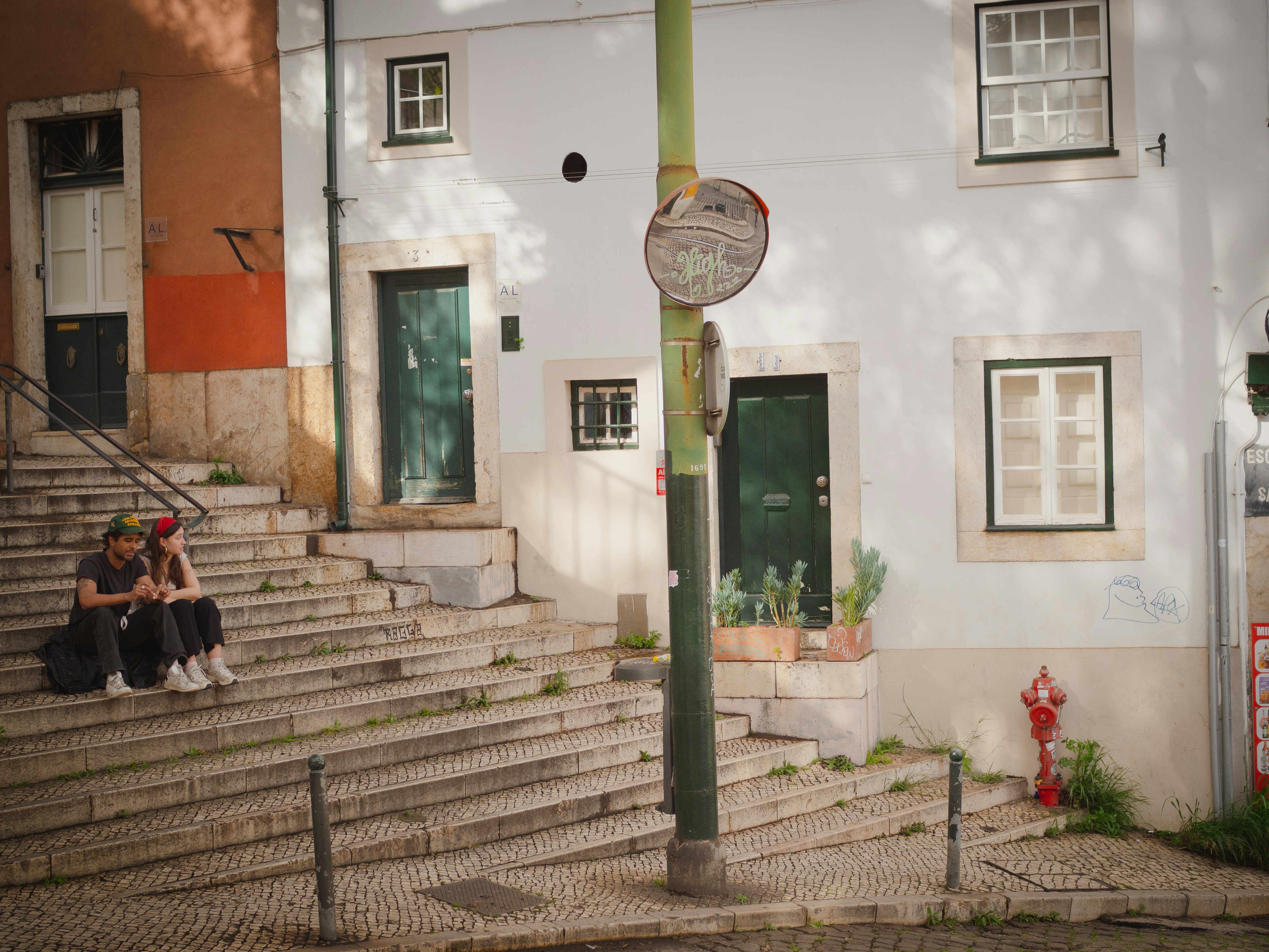 Quiet Corner: Two Friends on the Steps Under A Street Sign
