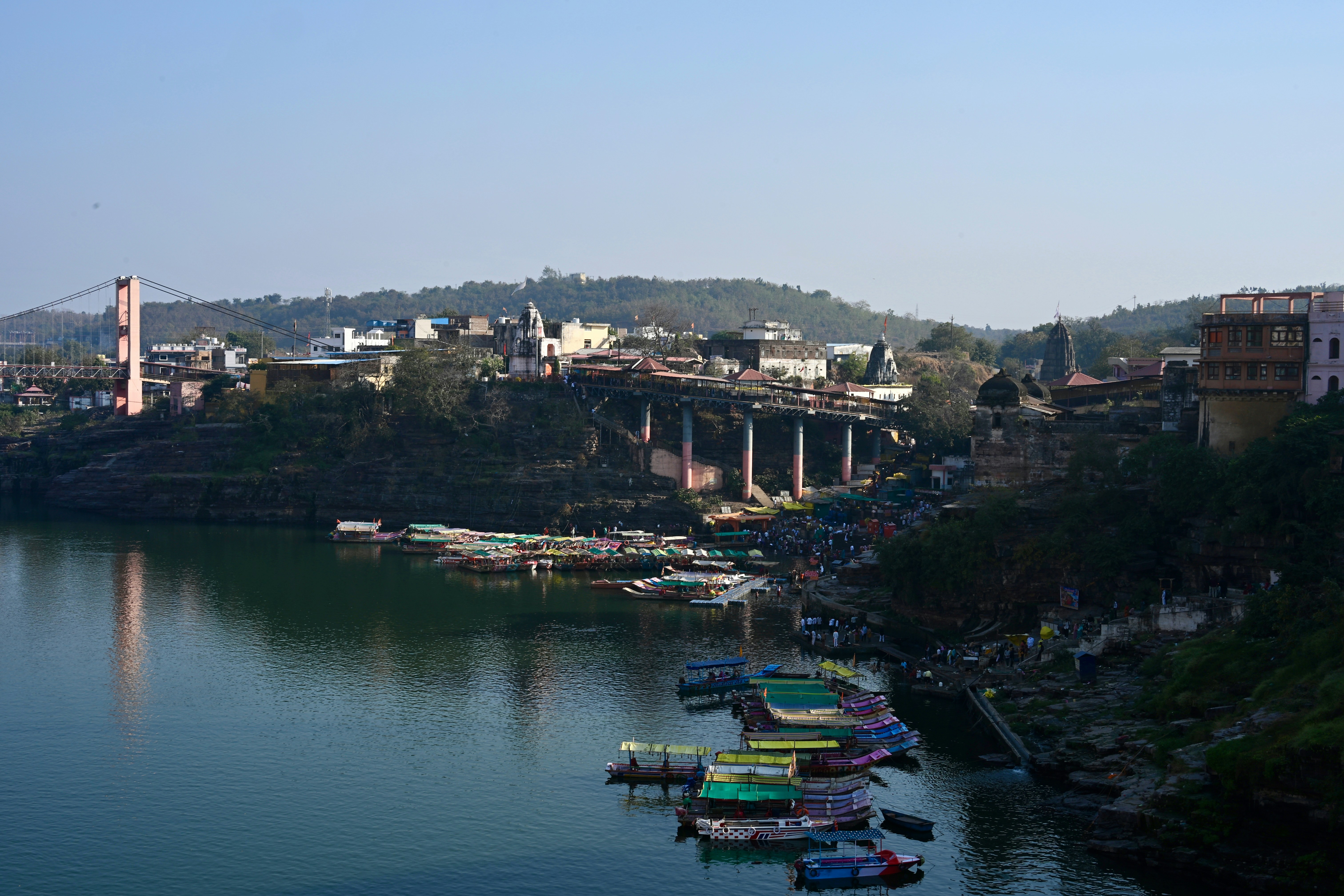 Riverside Exchange: Boats at Dusk Beside a Historic Bridge