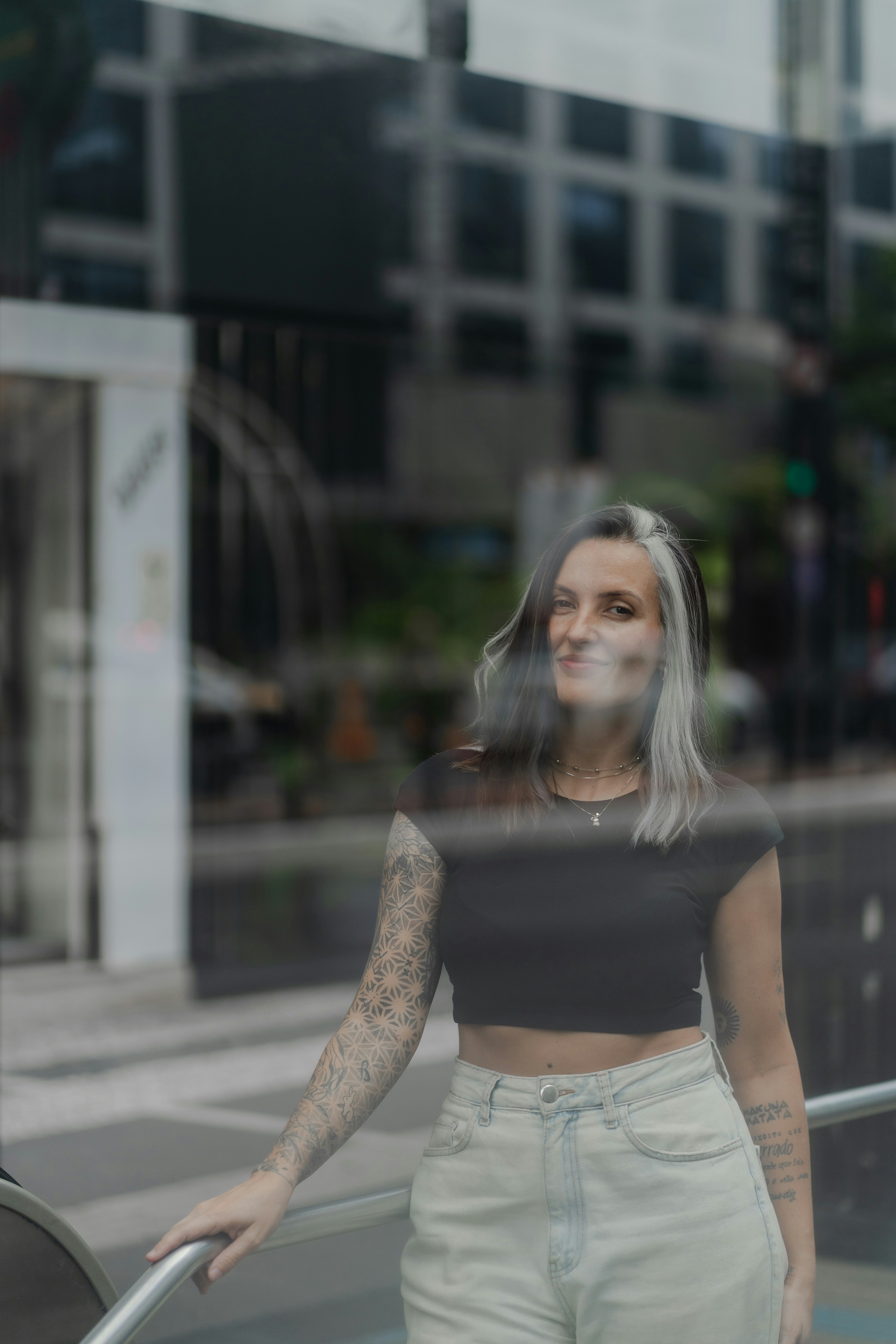 Glass-Window Portrait: A Confident Smile Behind Urban Glass