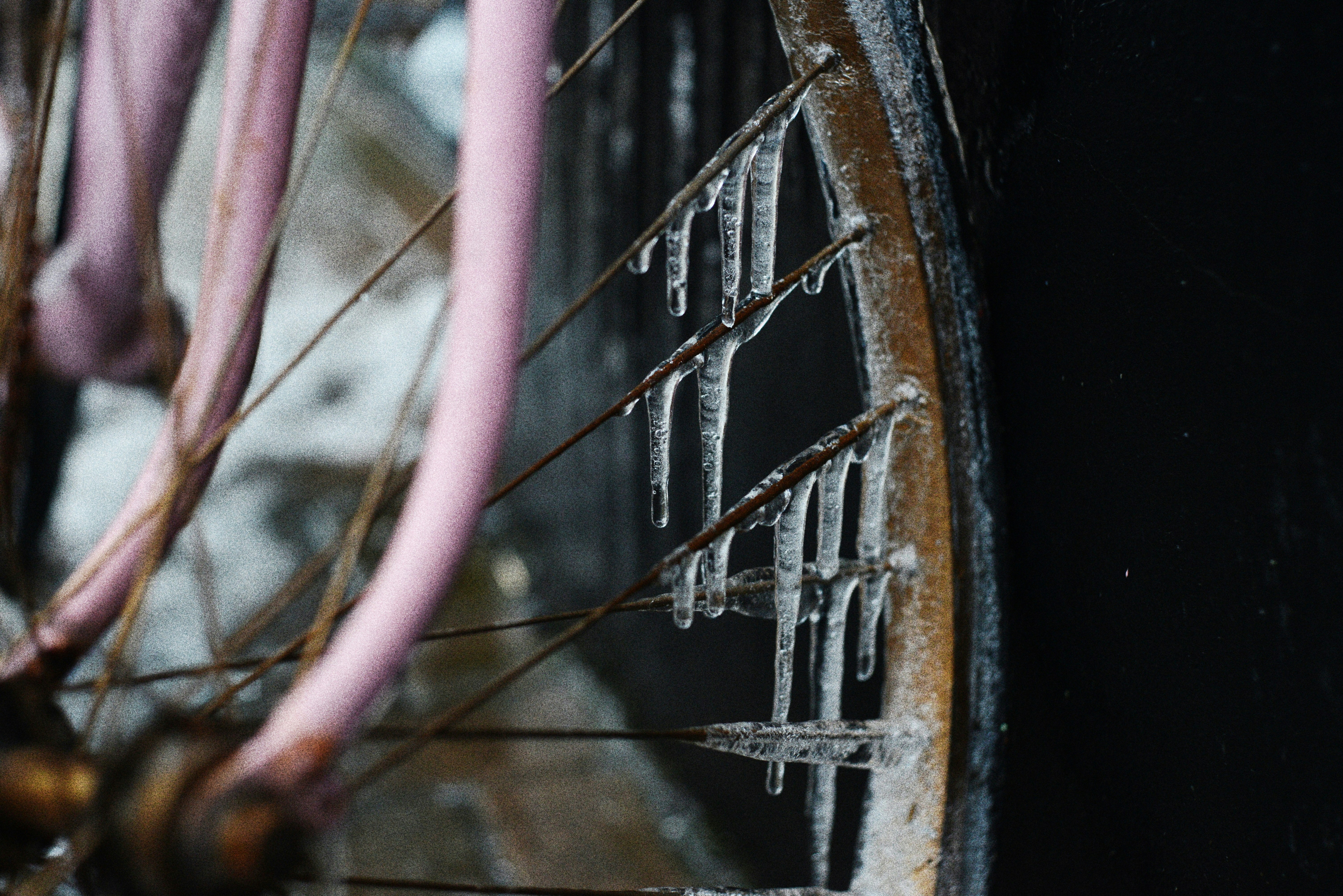 Rusting Spokes and Icicles: A Frozen Wheel Obscured by Wires