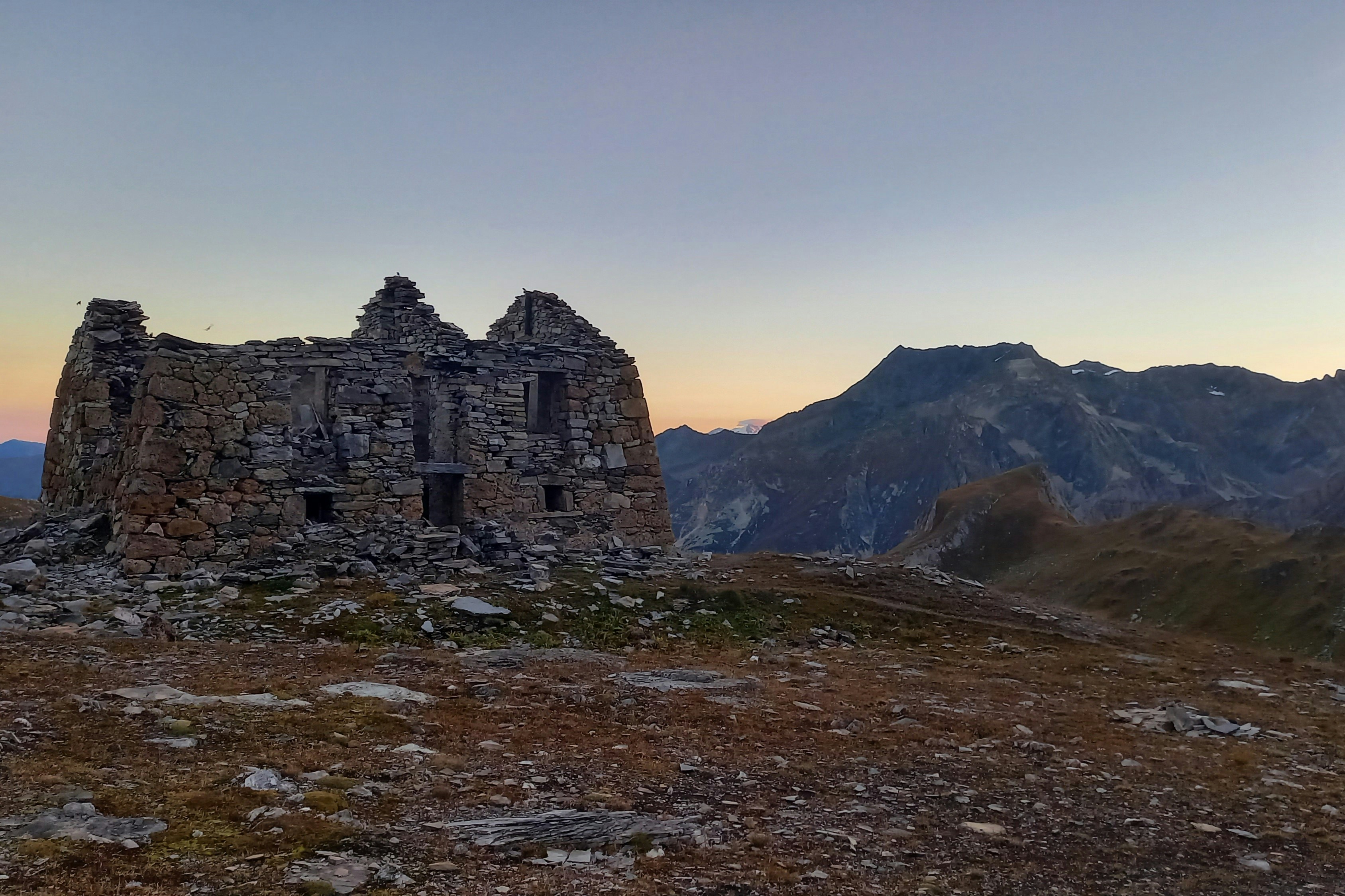 Ruined stone building on a mountain at dusk