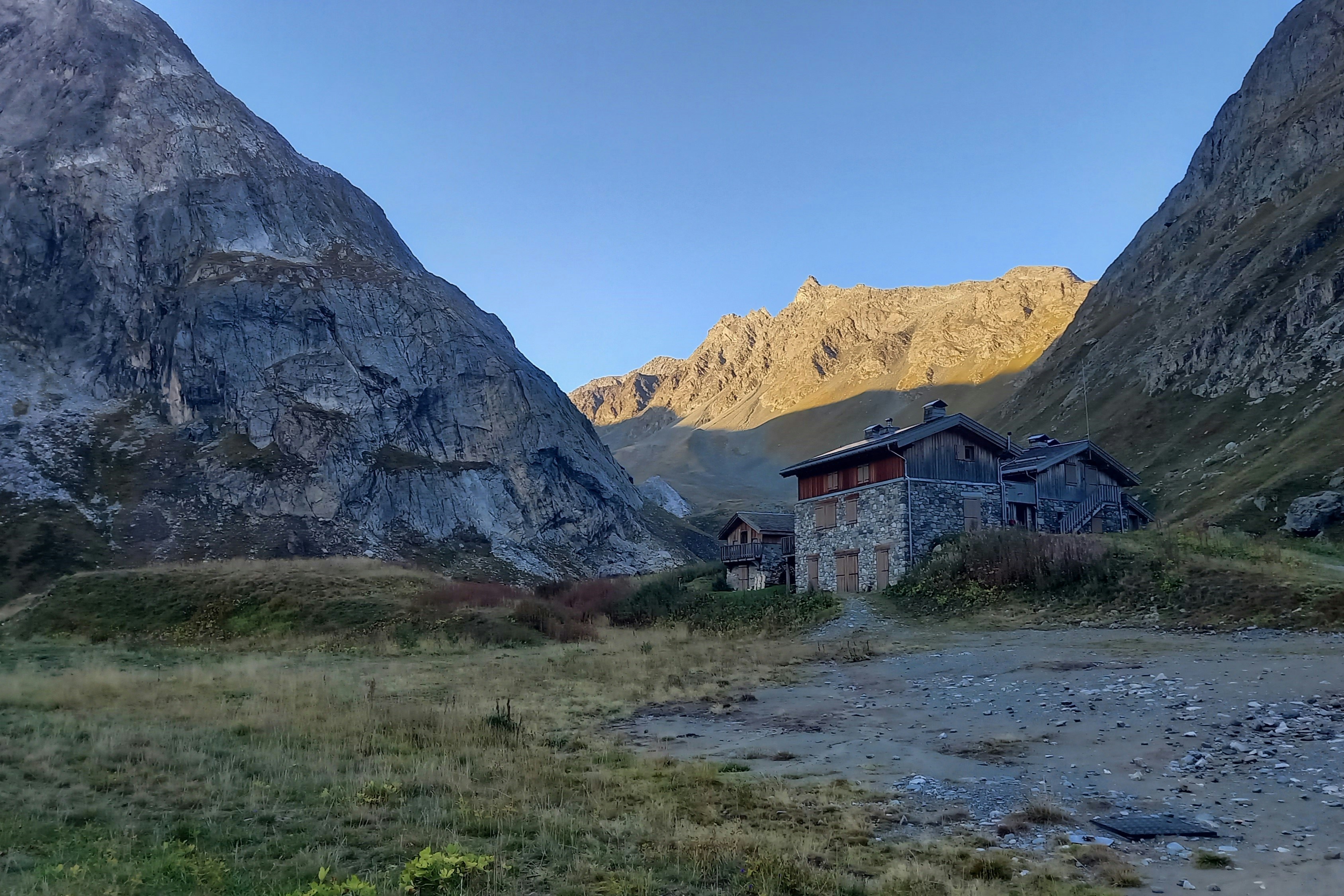 Stone mountain hut in a valley at sunrise