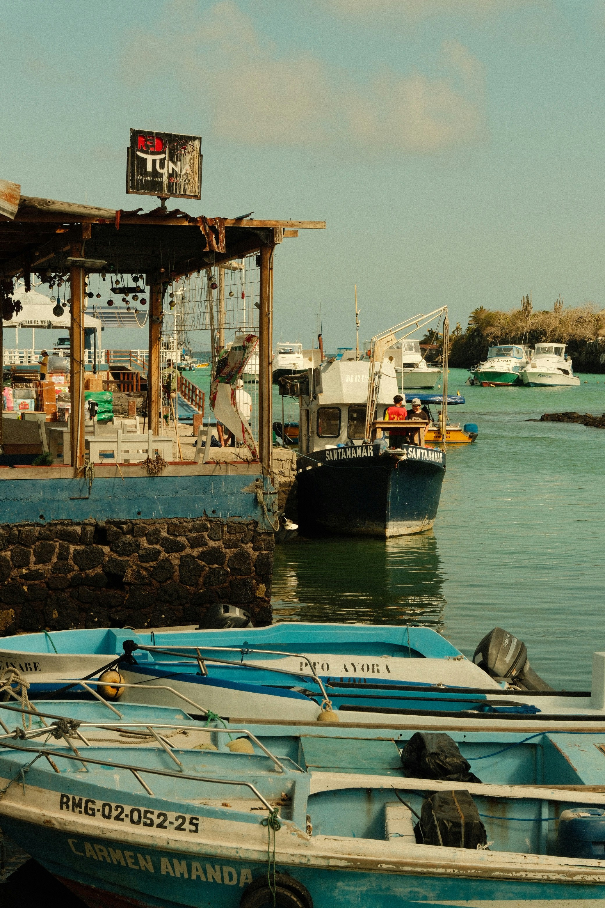 Harbor Docks at Golden Hour: Boats, Stone Pier, and a Weathered Tiki Bar