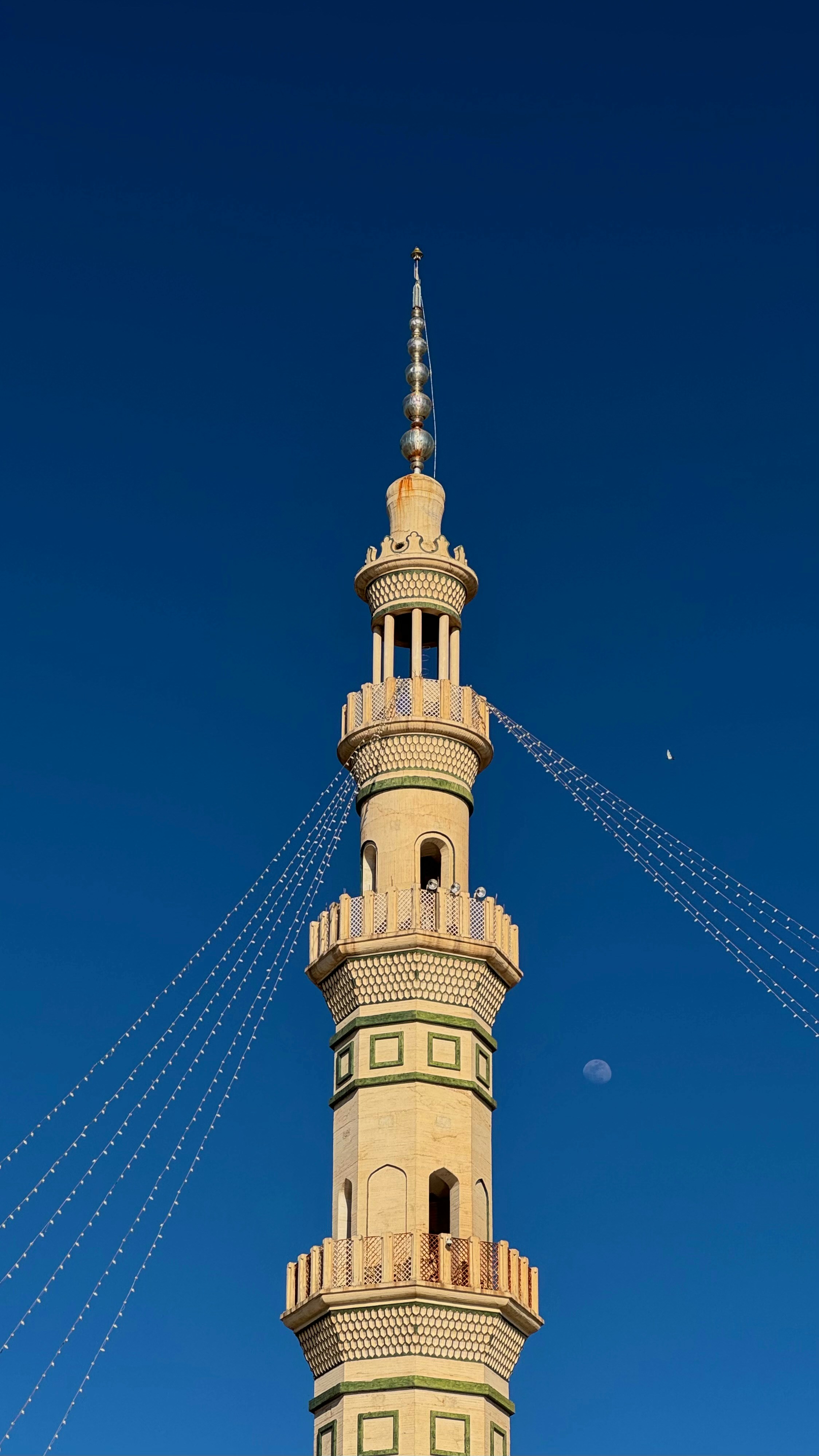 spire of light: a minaret against a clear azure sky