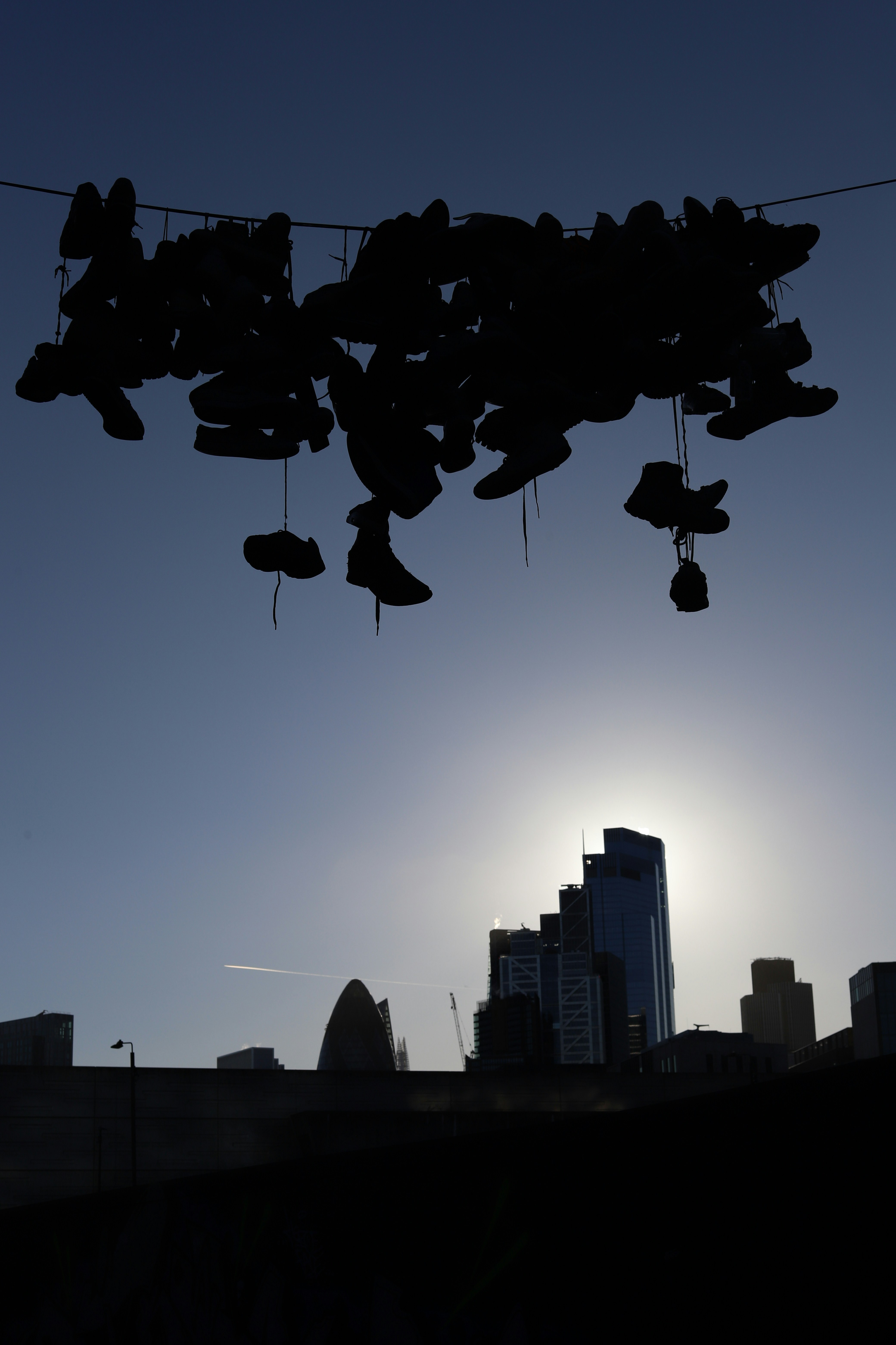 Silhouetted Shoes Over a City at Sunset