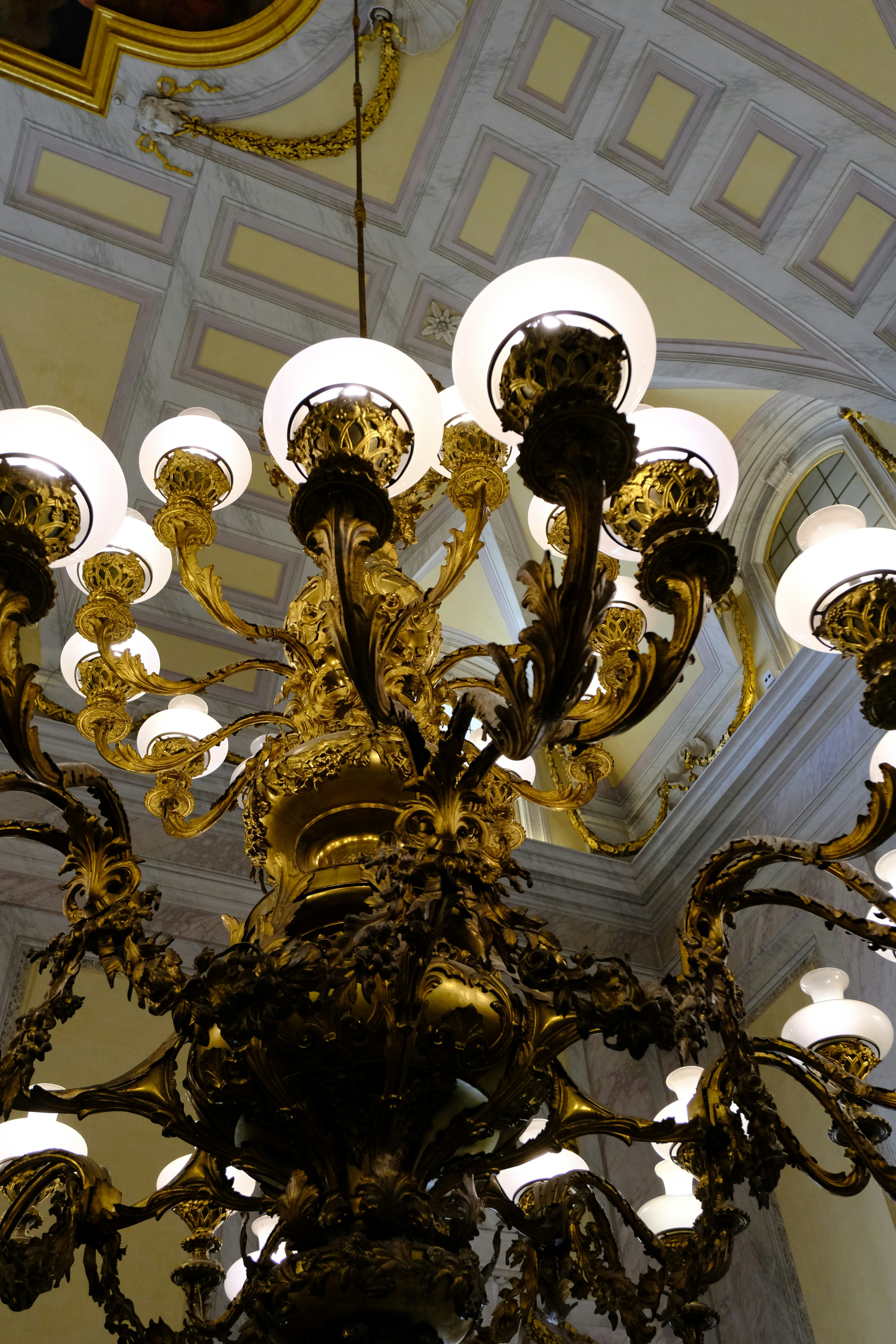 Gilded chandelier under ornate ceiling: a ballroom centerpiece