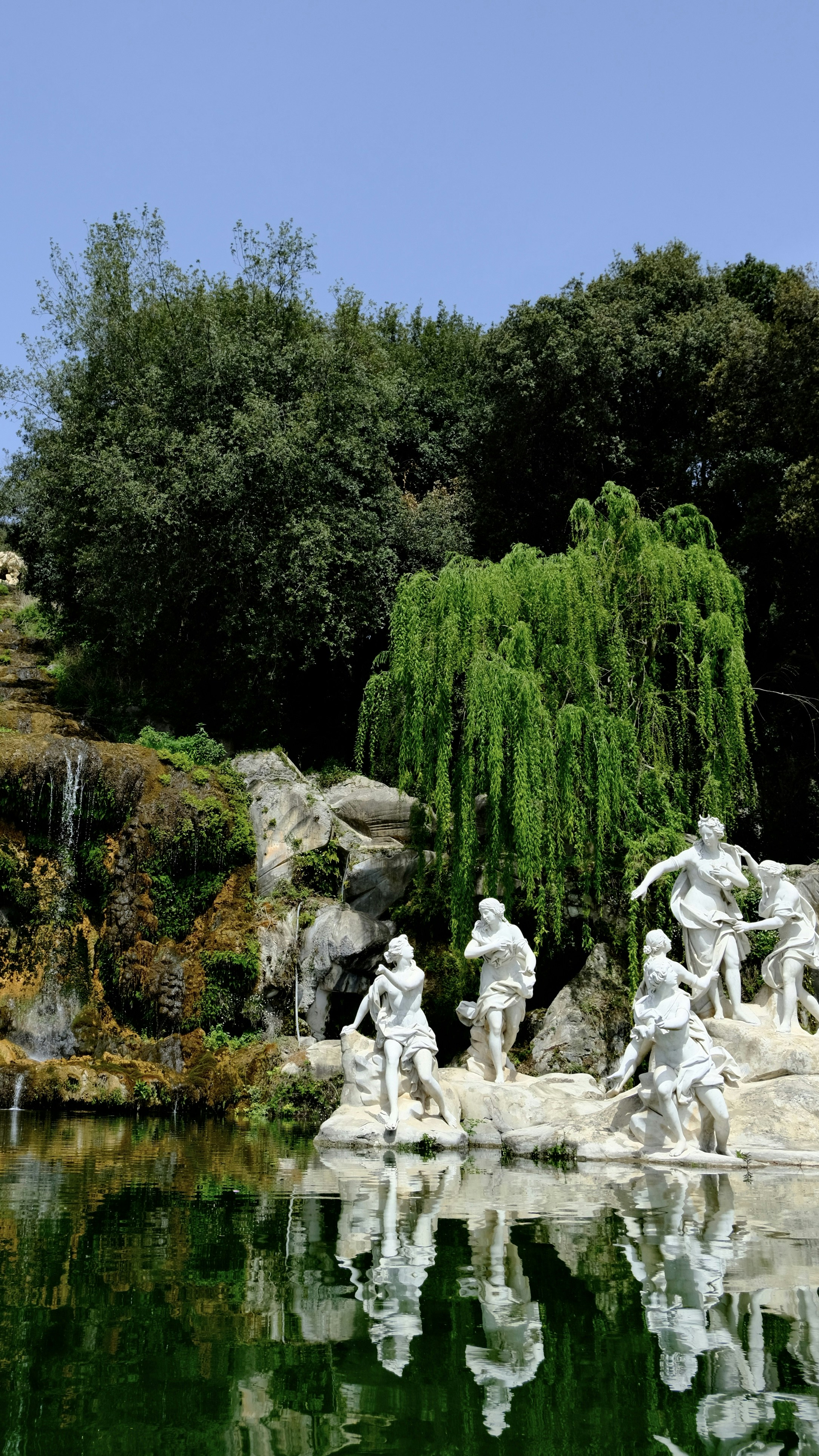 Stone Frescoes in Quiet Water: Classical Figures by a Green Cascade