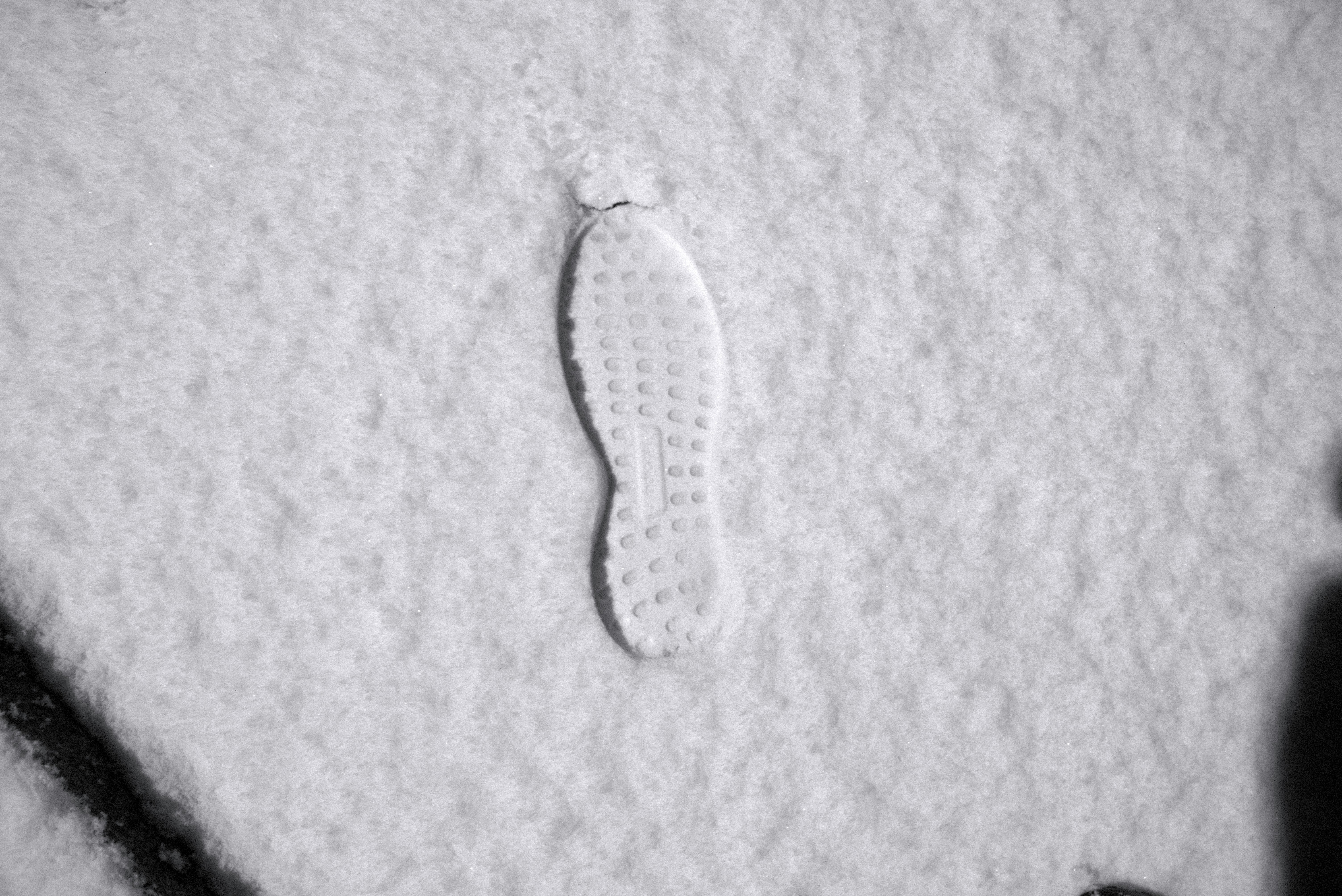 Snowbound Sole: a single tread mark on a quiet white canvas