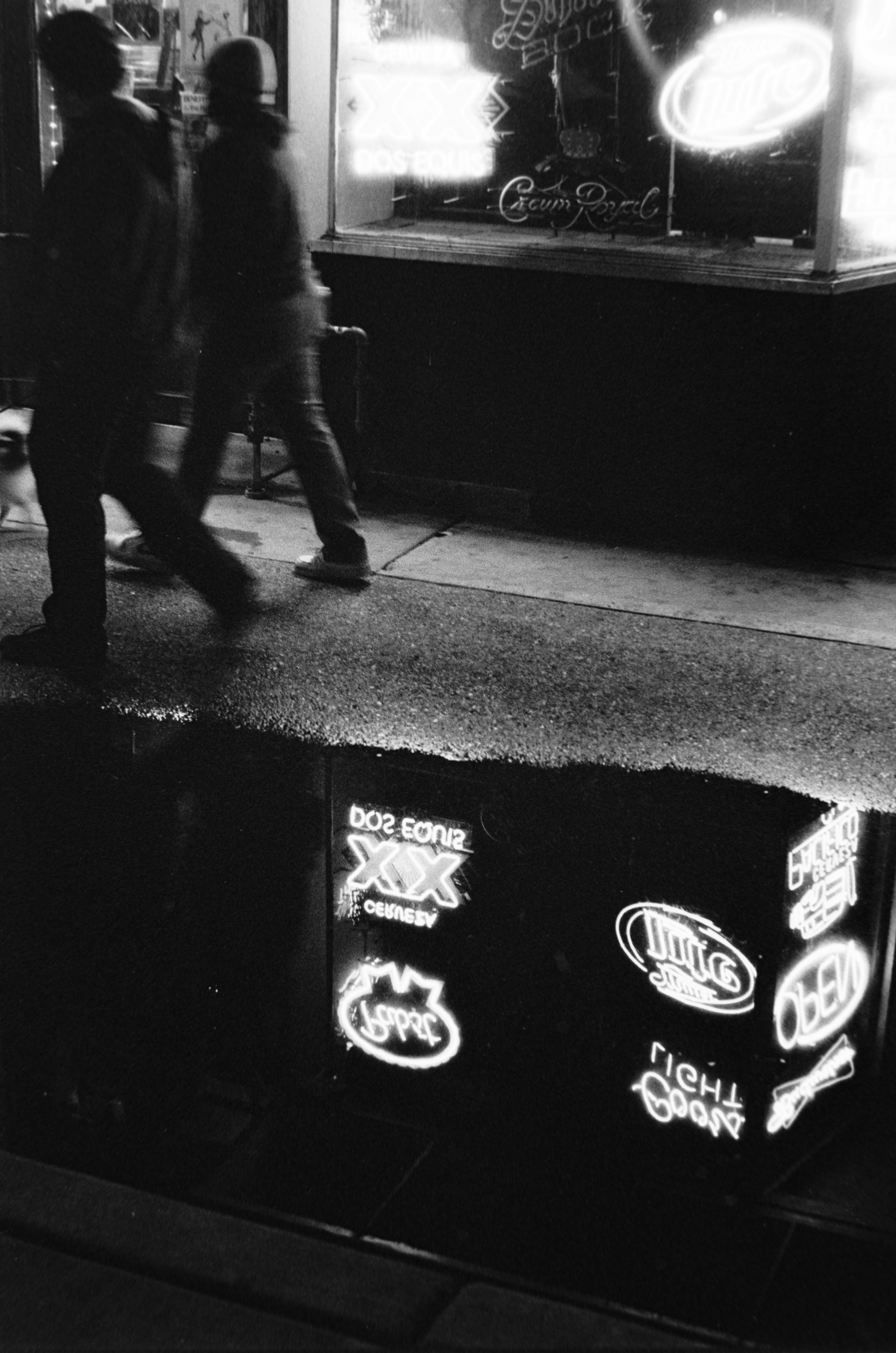 Neon Reflections on a Rainy Sidewalk