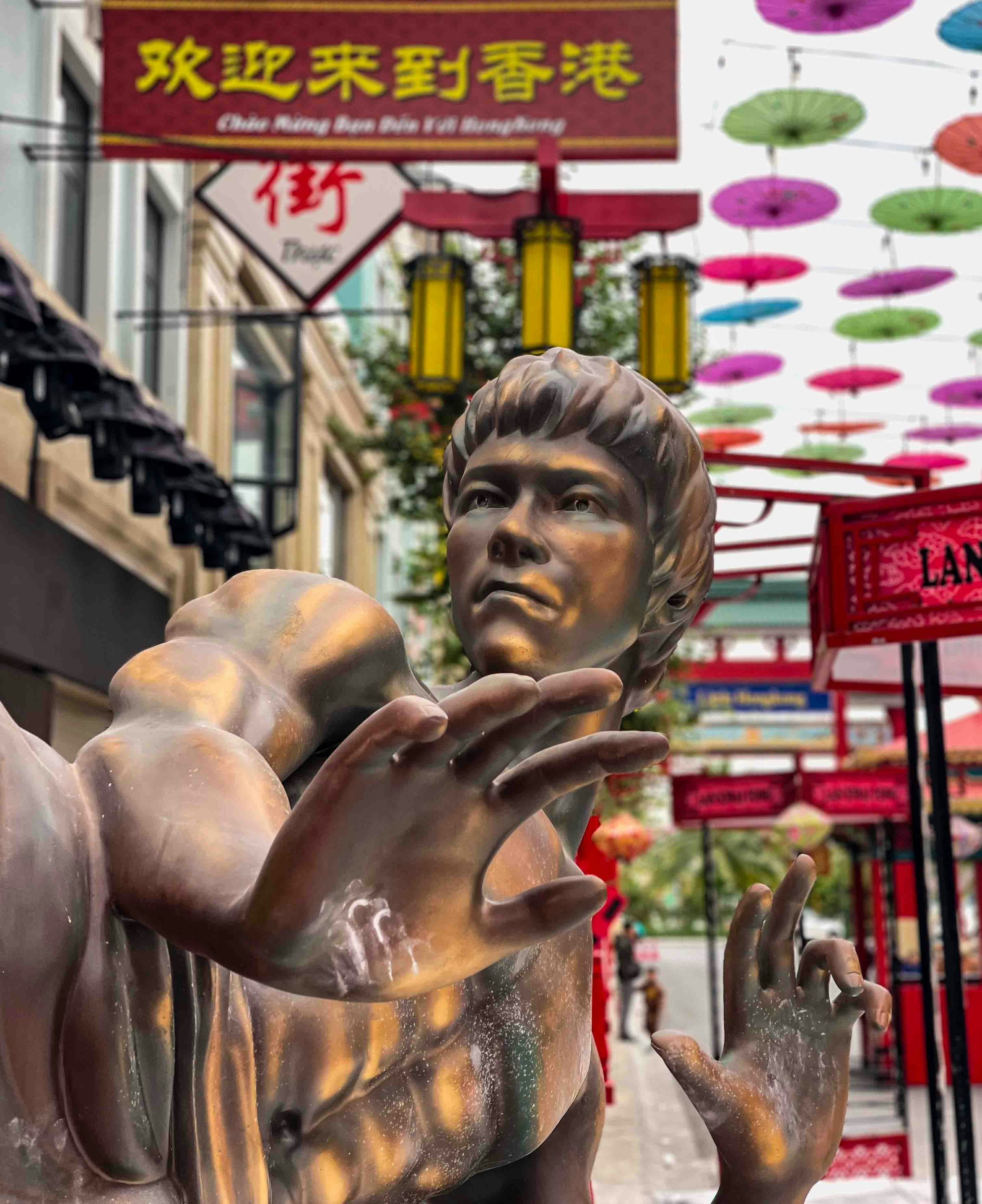 Bronze statue of bruce lee in chinatown with umbrellasBernd 📷 Dittrich