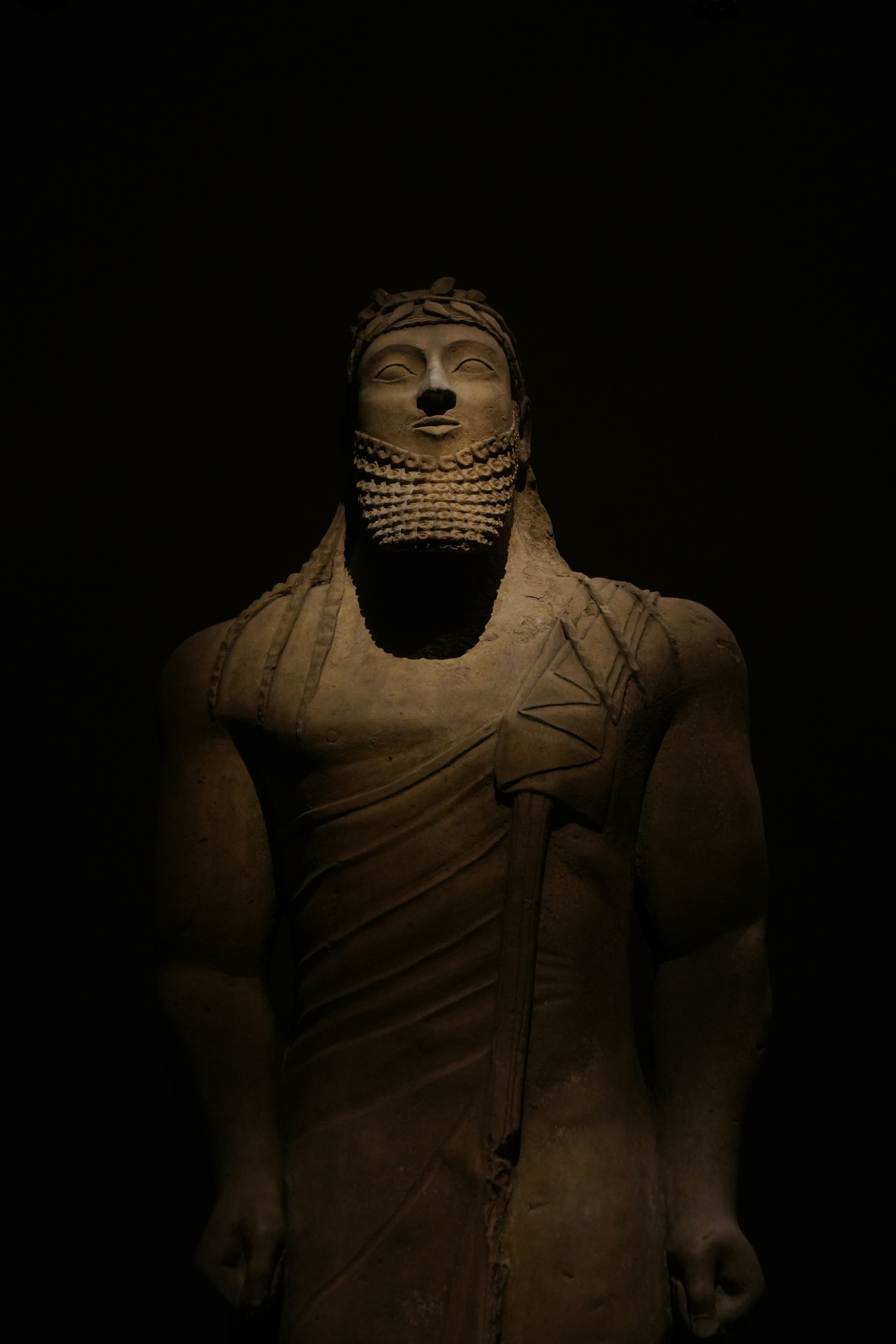 Shadowed Guardian: A Stoic Statue Emerges from Darkness