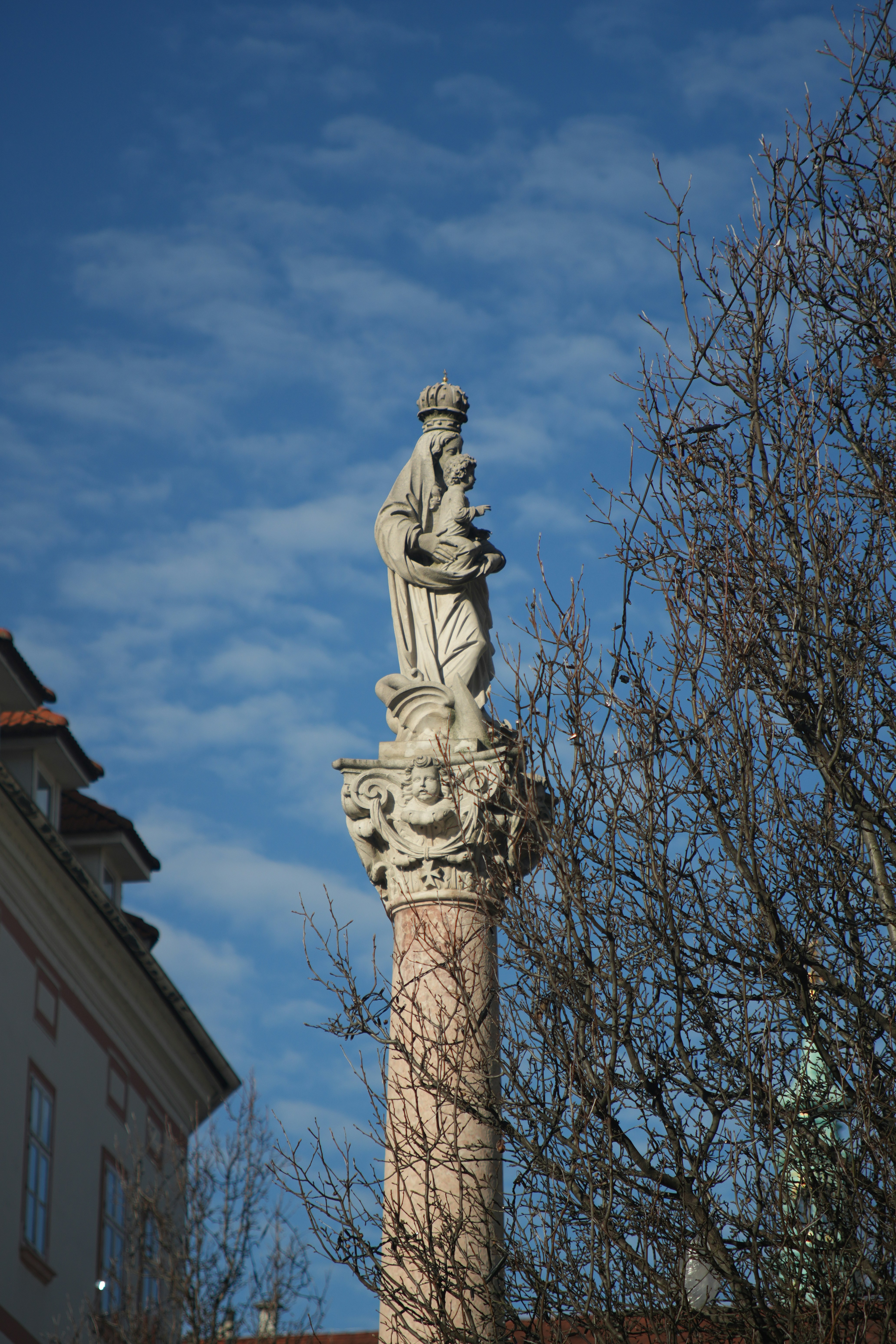 Saintly Sentinel: A Column Statue Reaching Toward the Sky