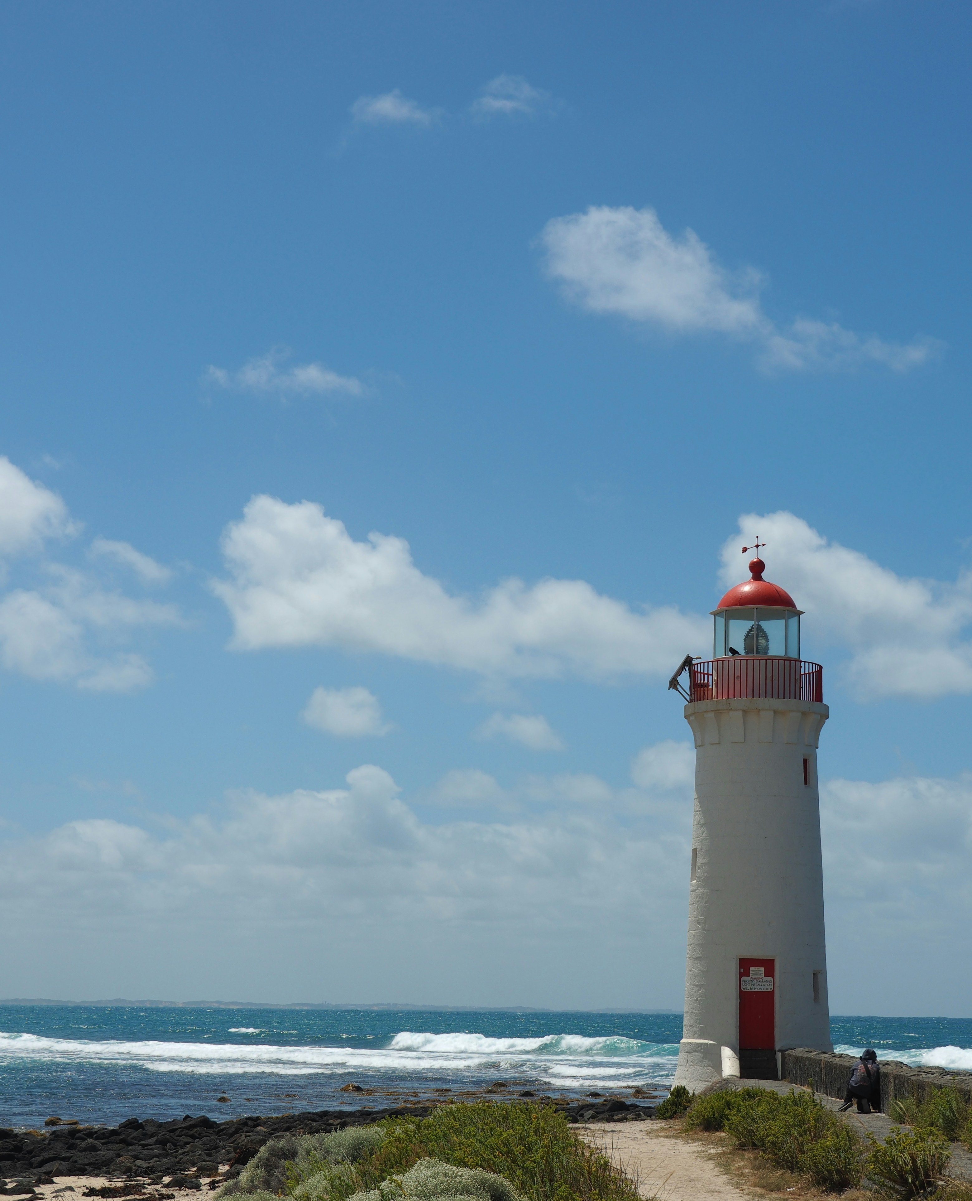 Lighthouse on the Edge: A Seaside Sentinel Under Open Skies