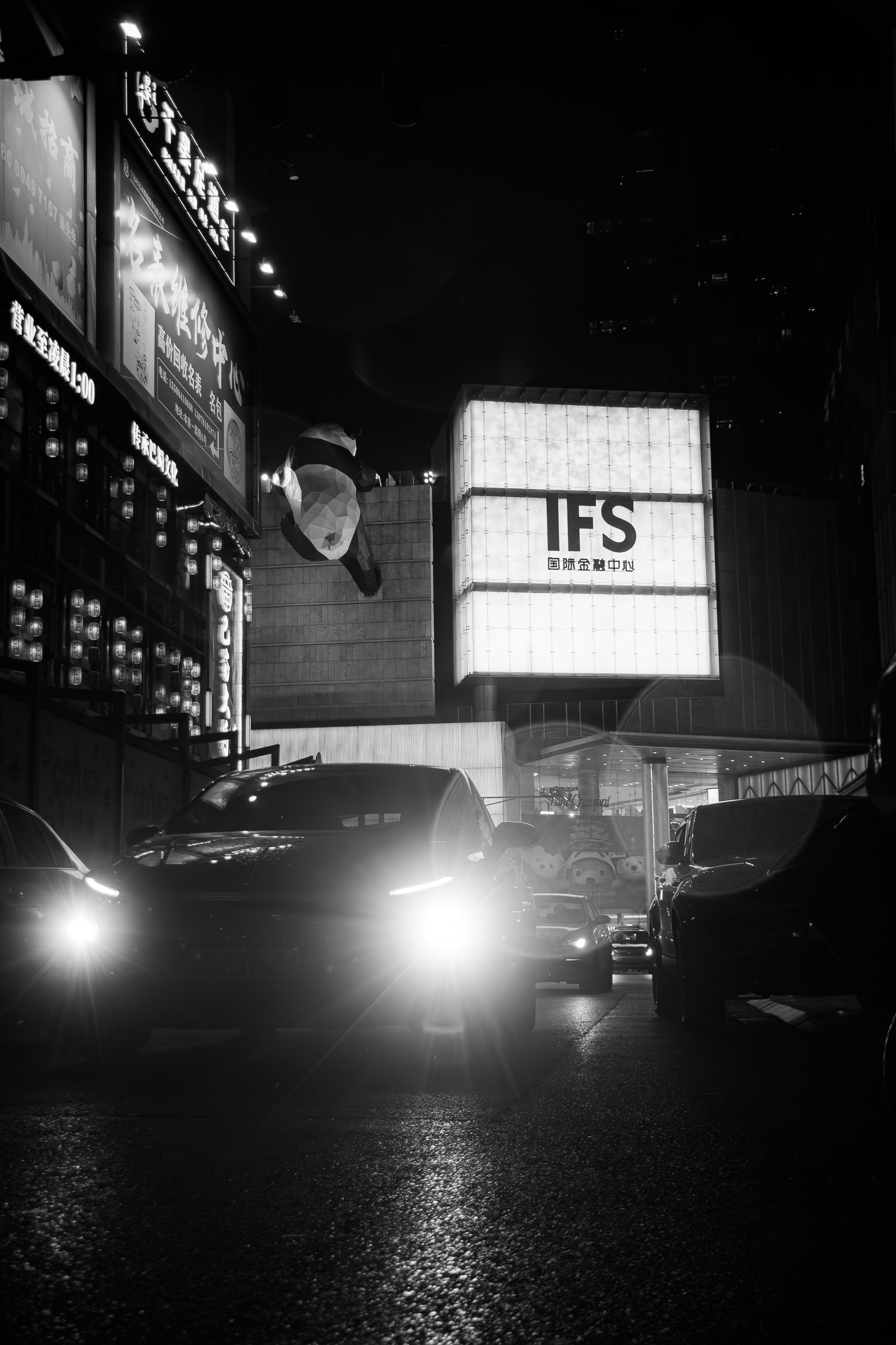 Neon Alley: Headlights and Signage in Rainy Night Traffic