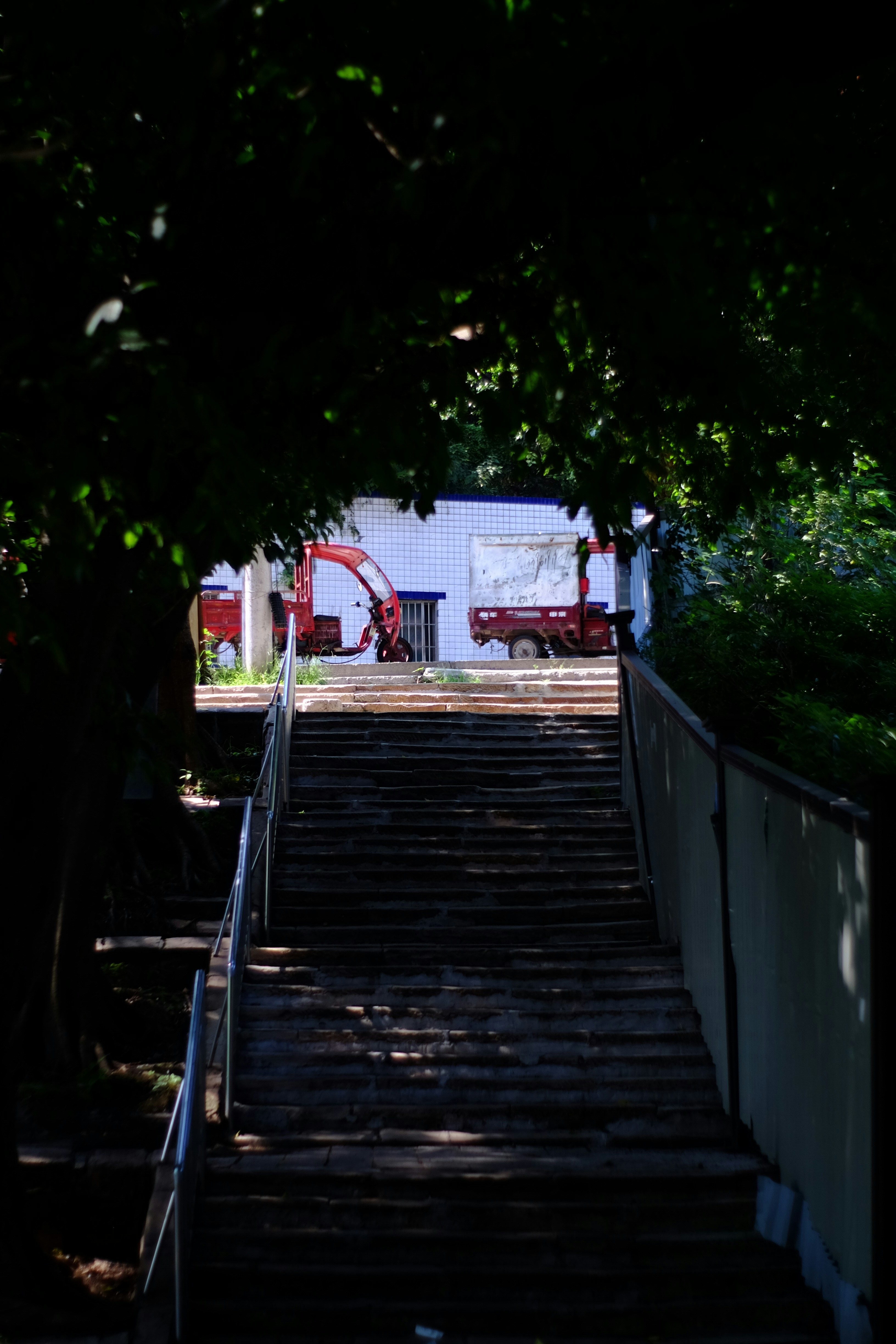 Light at the Summit: Stairs leading to a parked truck and red machinery
