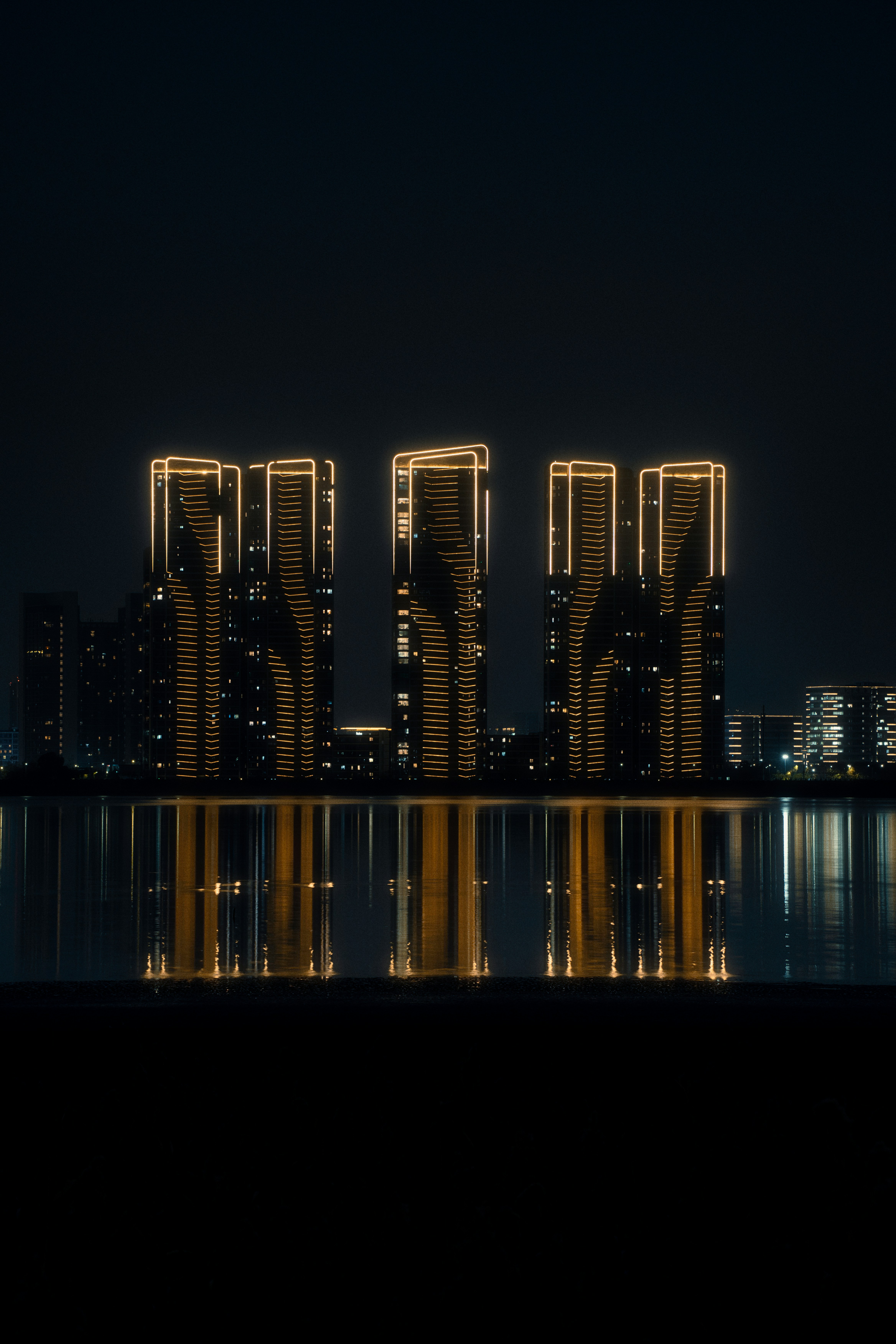 Neon Skyline Reflections: Towers of Light on a Quiet River