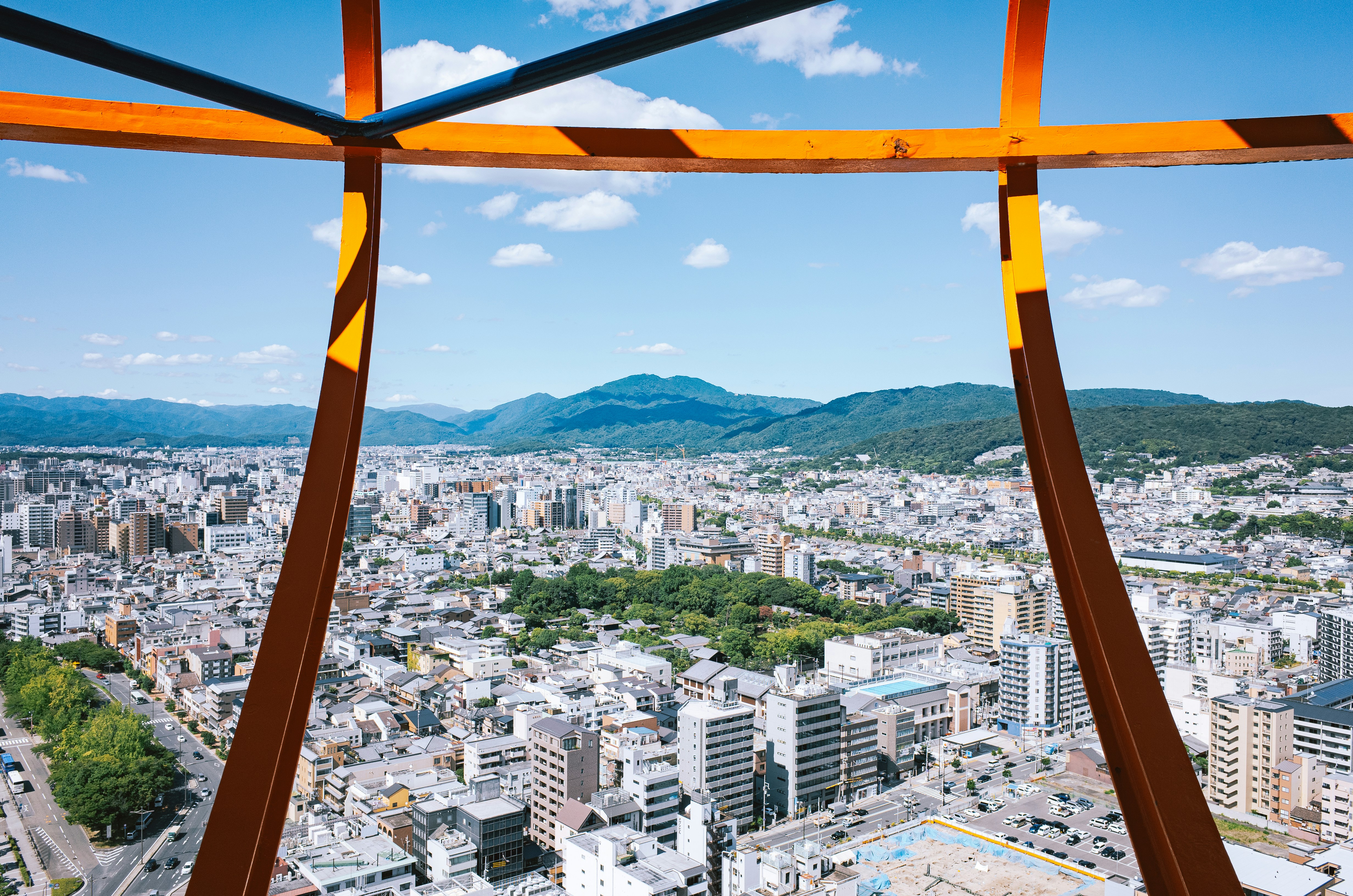 Urban panorama framed by orange girders