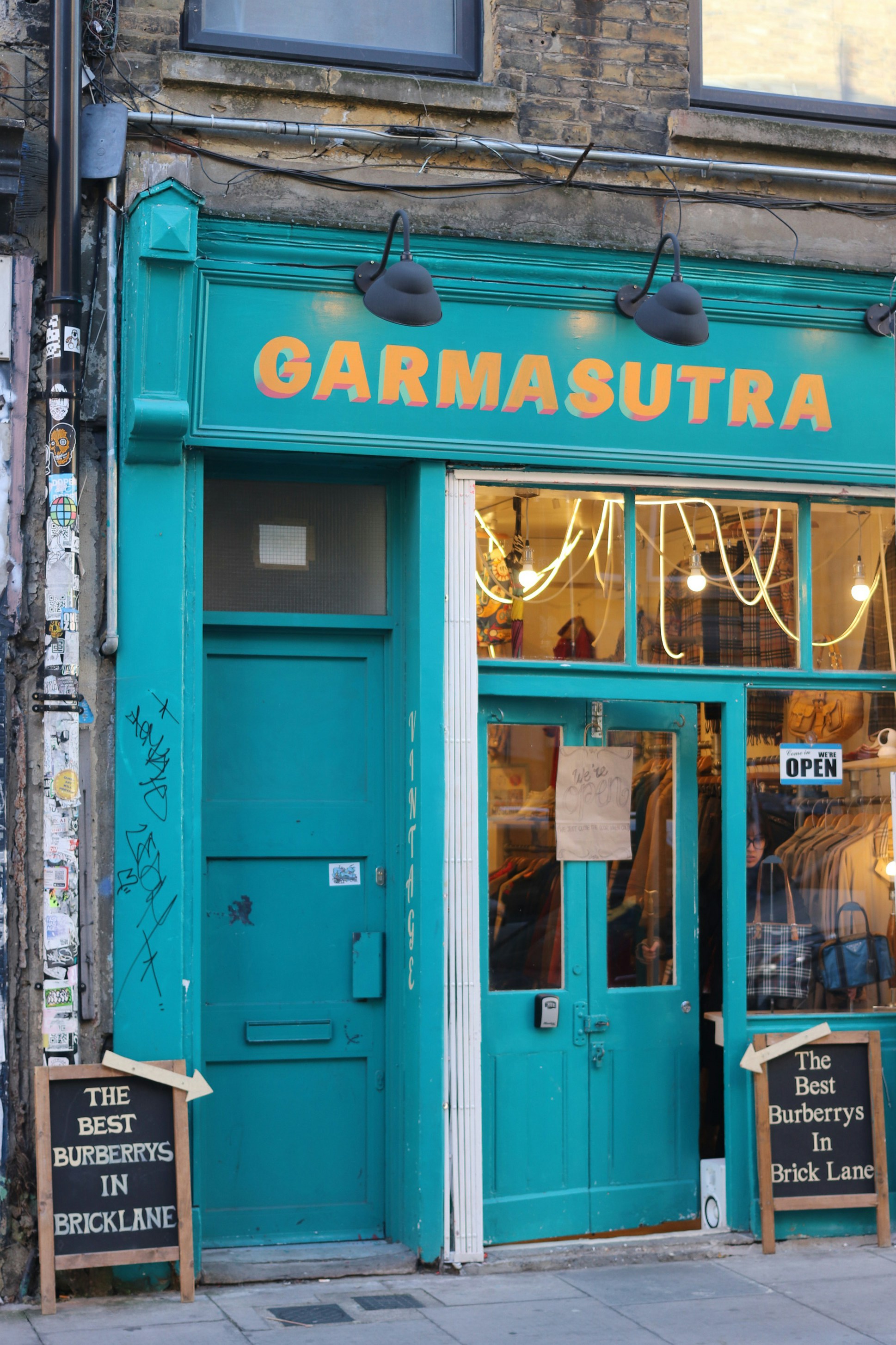 Turquoise storefront of GARMASUTRA: An inviting brick-and-mortar boutique reachout