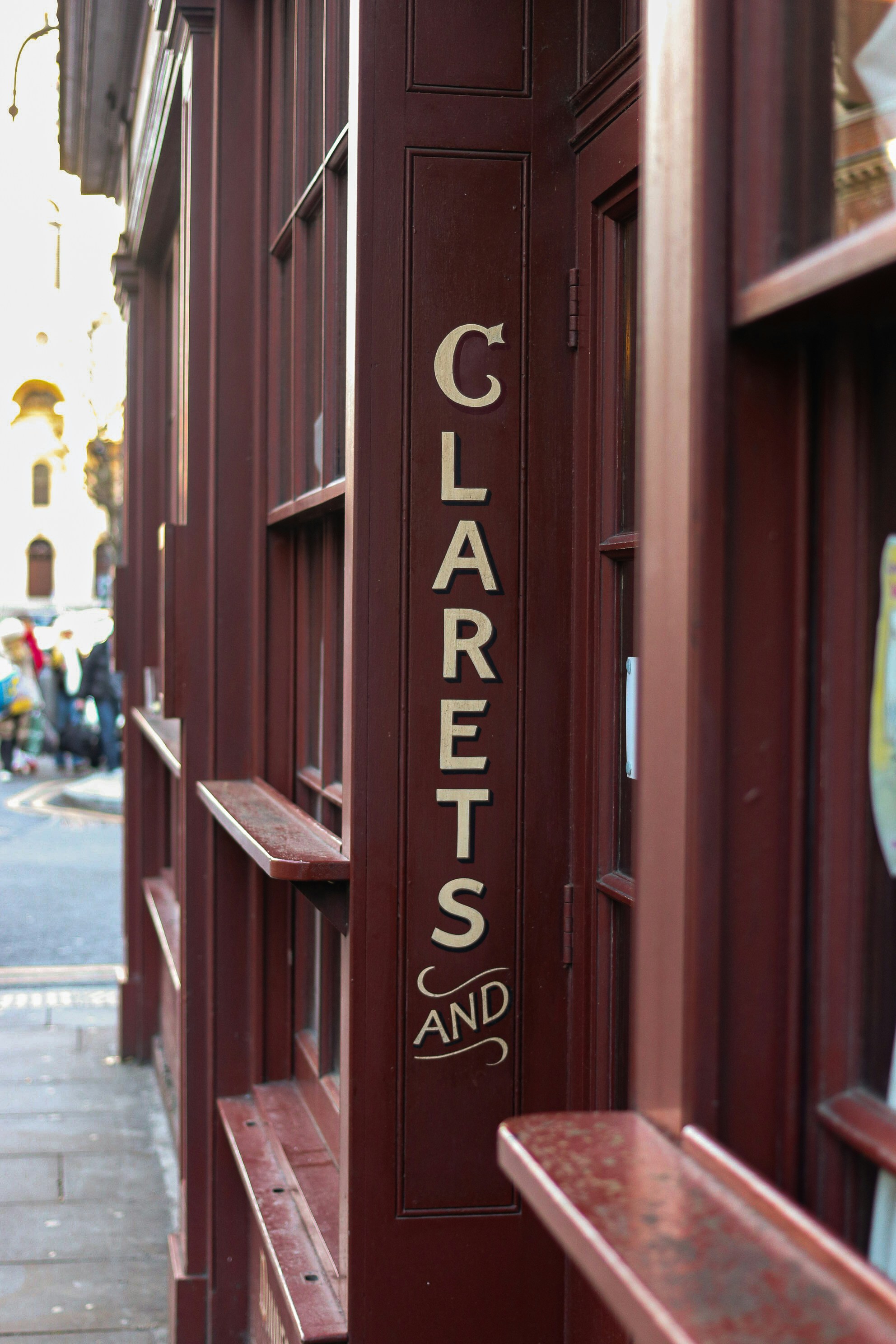 Maroon Facade: Claret vertical sign in a narrow street