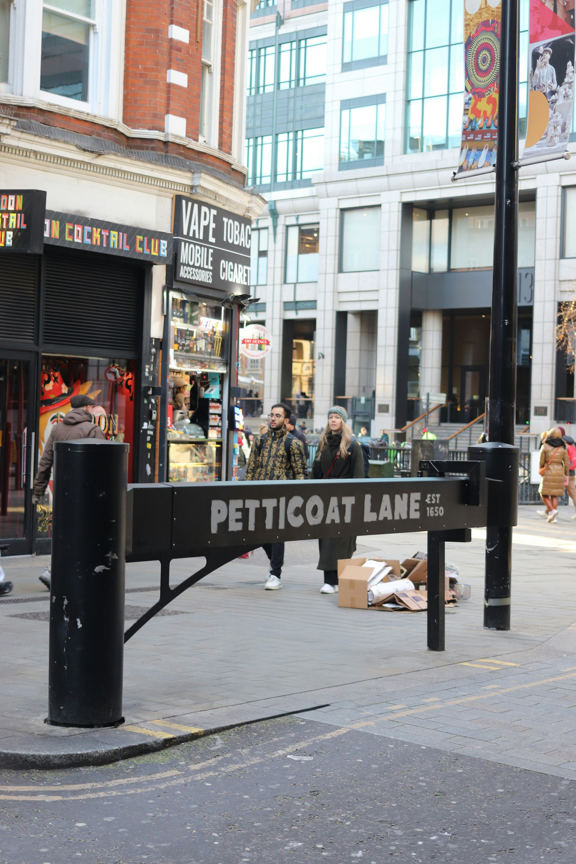 Petticoat Lane: Pedestrian Alleyway Amid Shops and Curious Street Scene