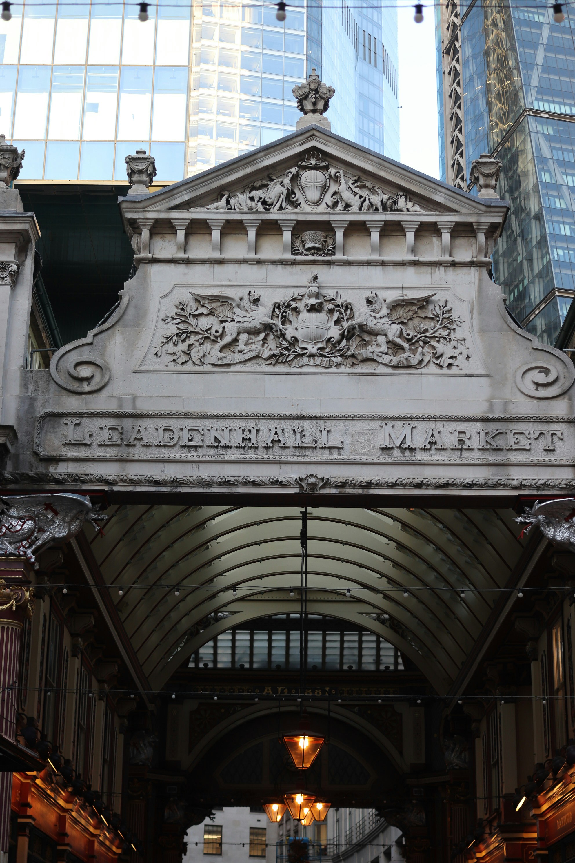 Stone Facade of Leadenhall Market Framed by Modern Glass Skyscrapers