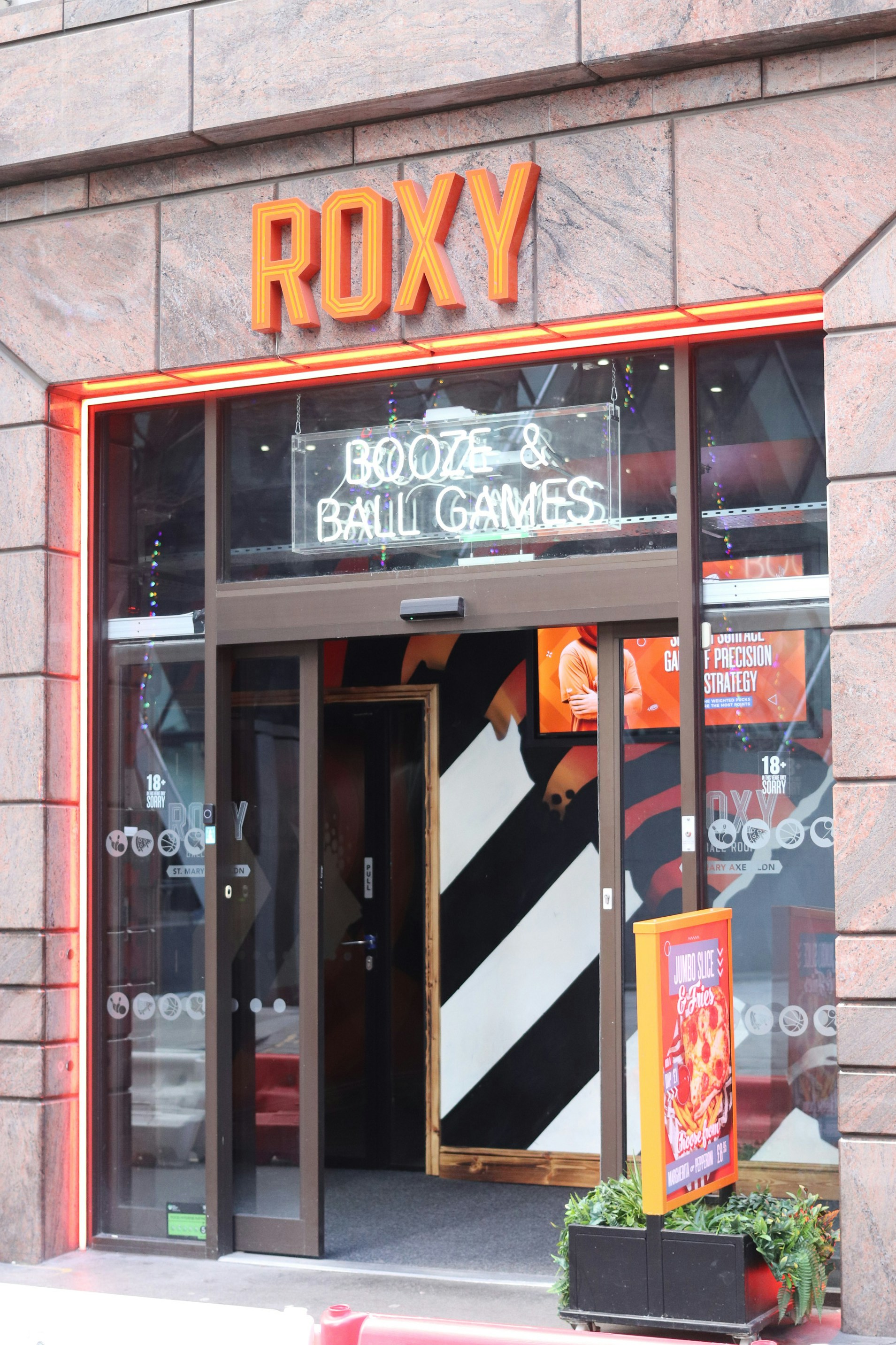 Roxy Entrance: Neon Sign, Glass Doors, and Checker Stripe Interior