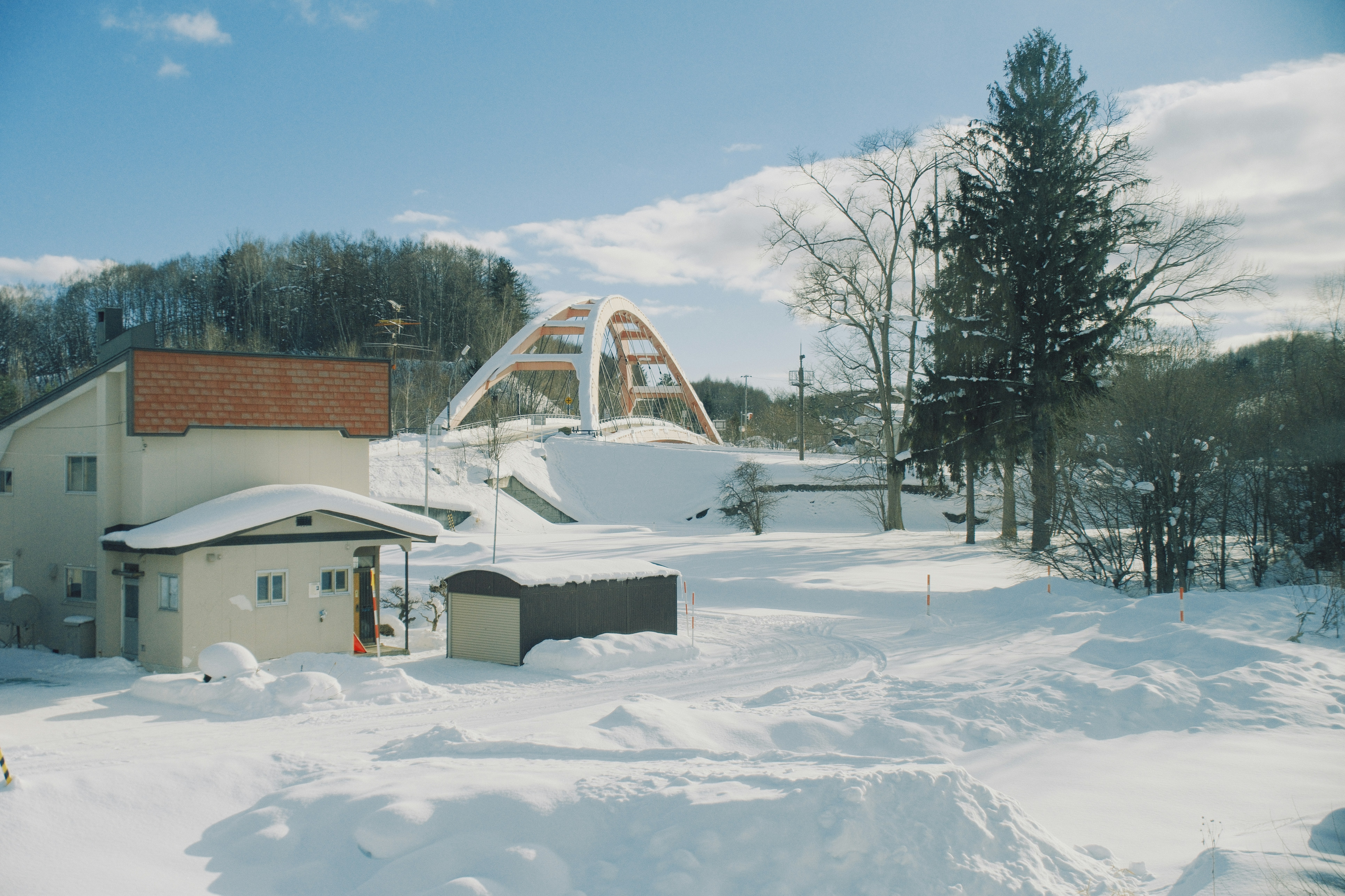 Snowy Riverside Complex under a Modern Arch Bridge