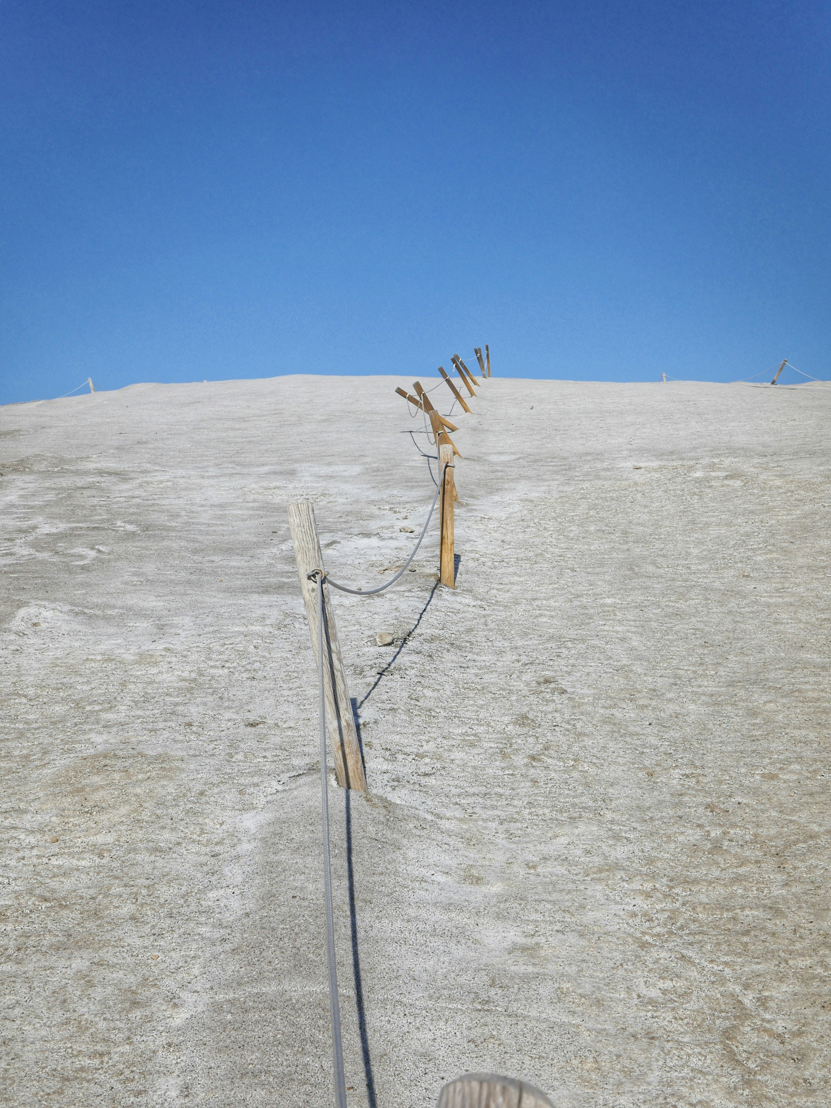 Ridge Line with Weathered Post Fence under Clear Blue Sky