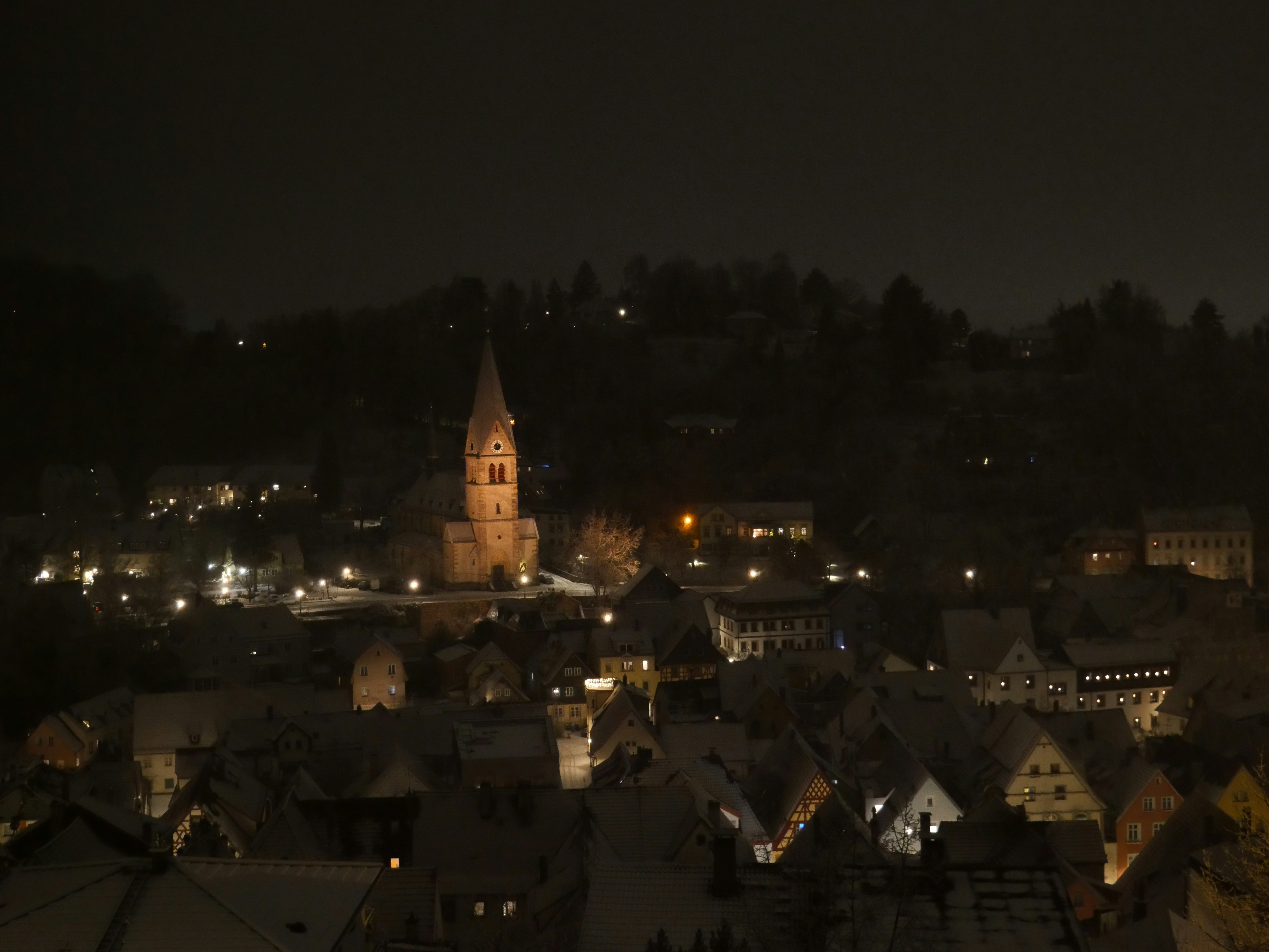 Nightfall in the Old Town: A Quiet Cathedral Spire Amid Lit Rooflines