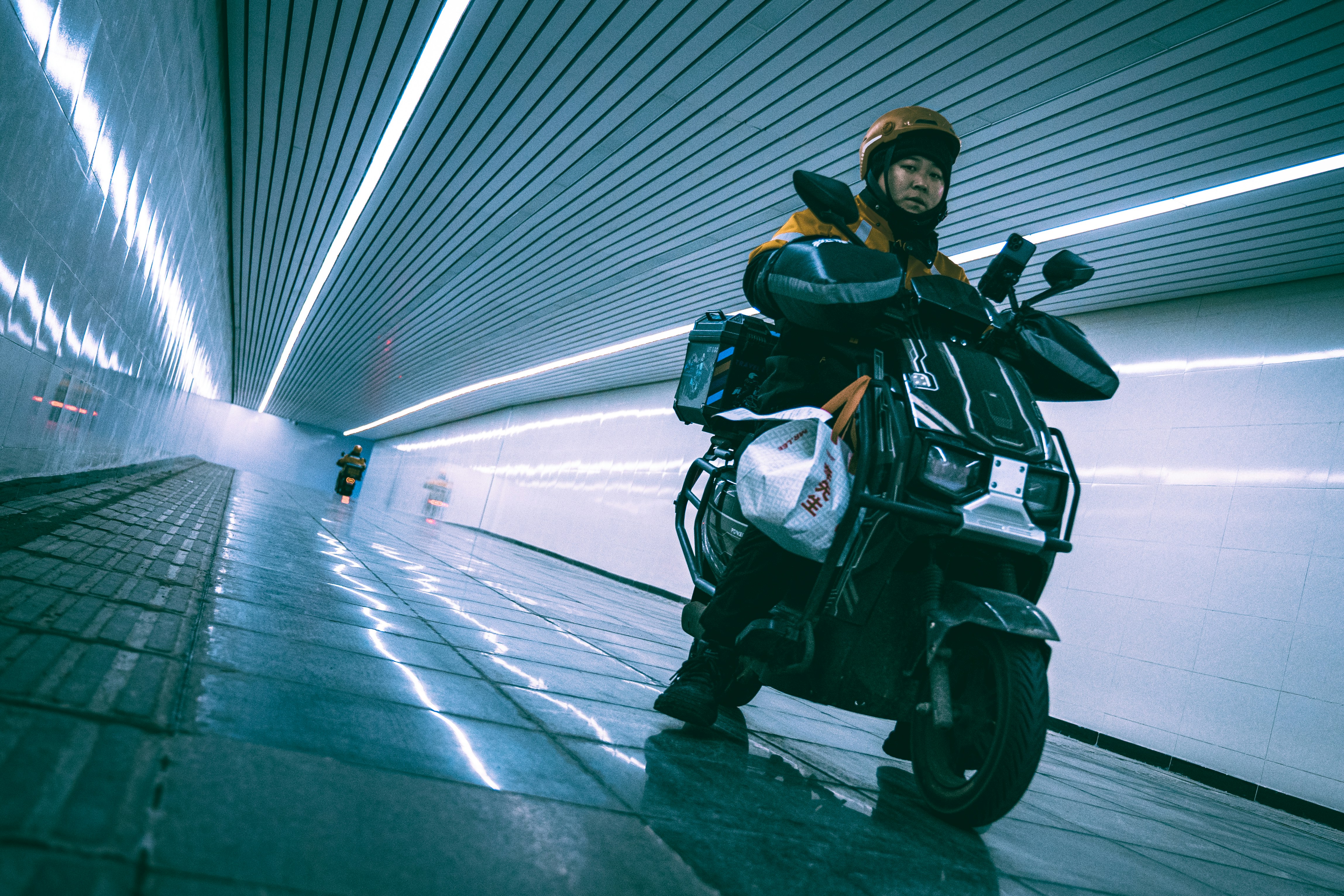  rider on a neon-lit tunnel scooter