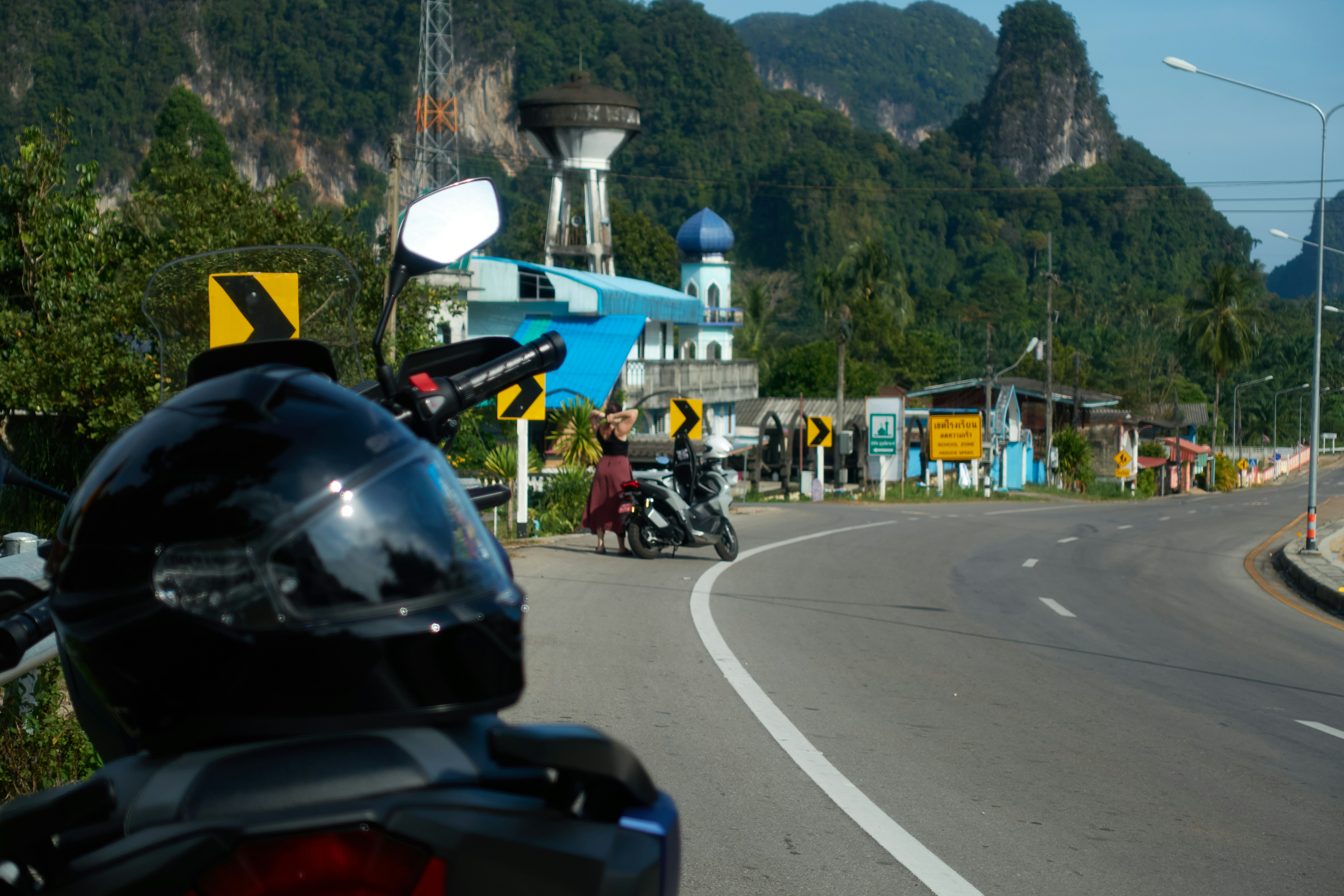 Oncoming Route: A Scooter Closes the Curve Past a Scenic Canyon