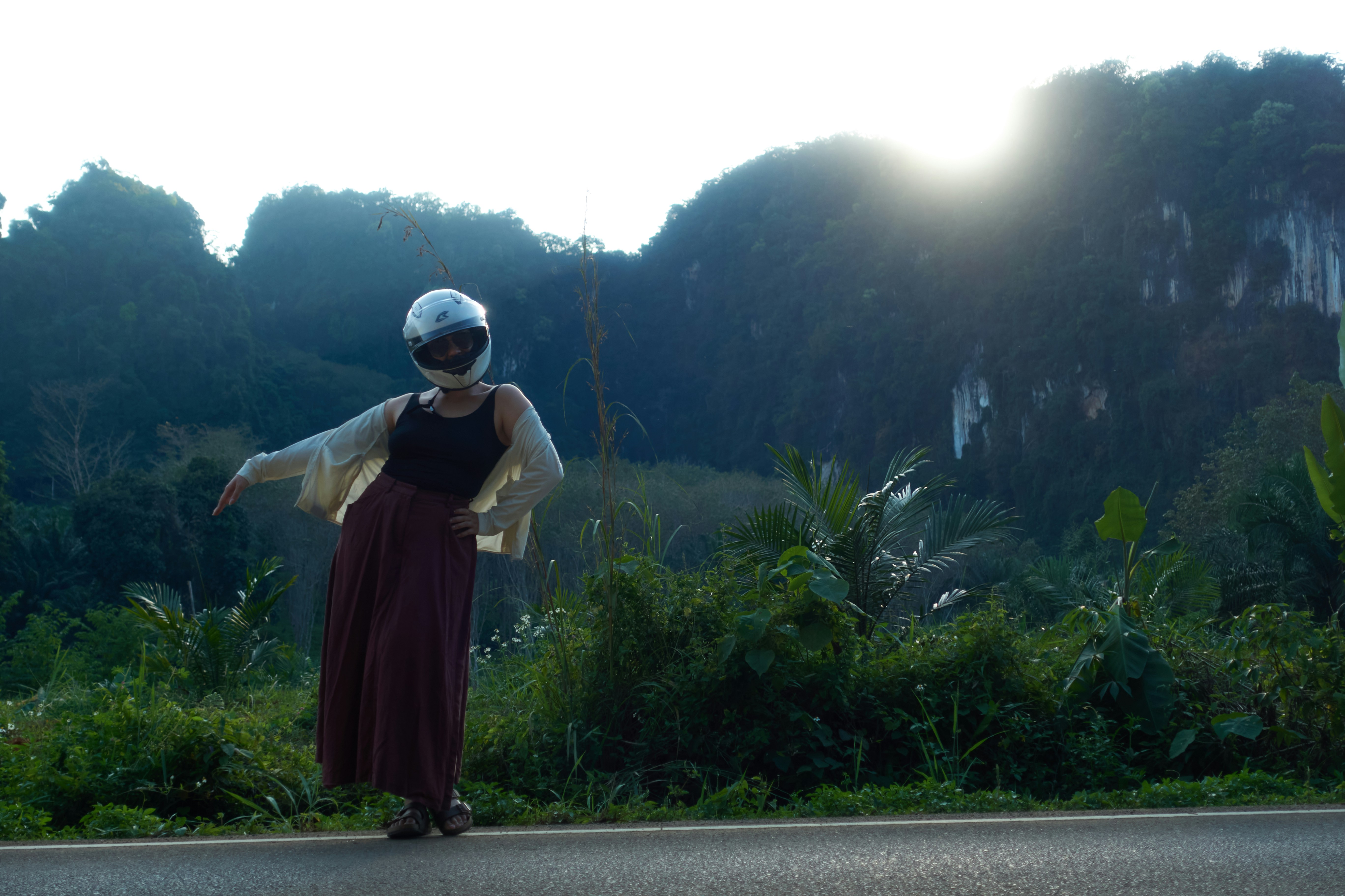 Ragged-Flow Dress and Helmet on a Quiet Road by Verdant Cliffs