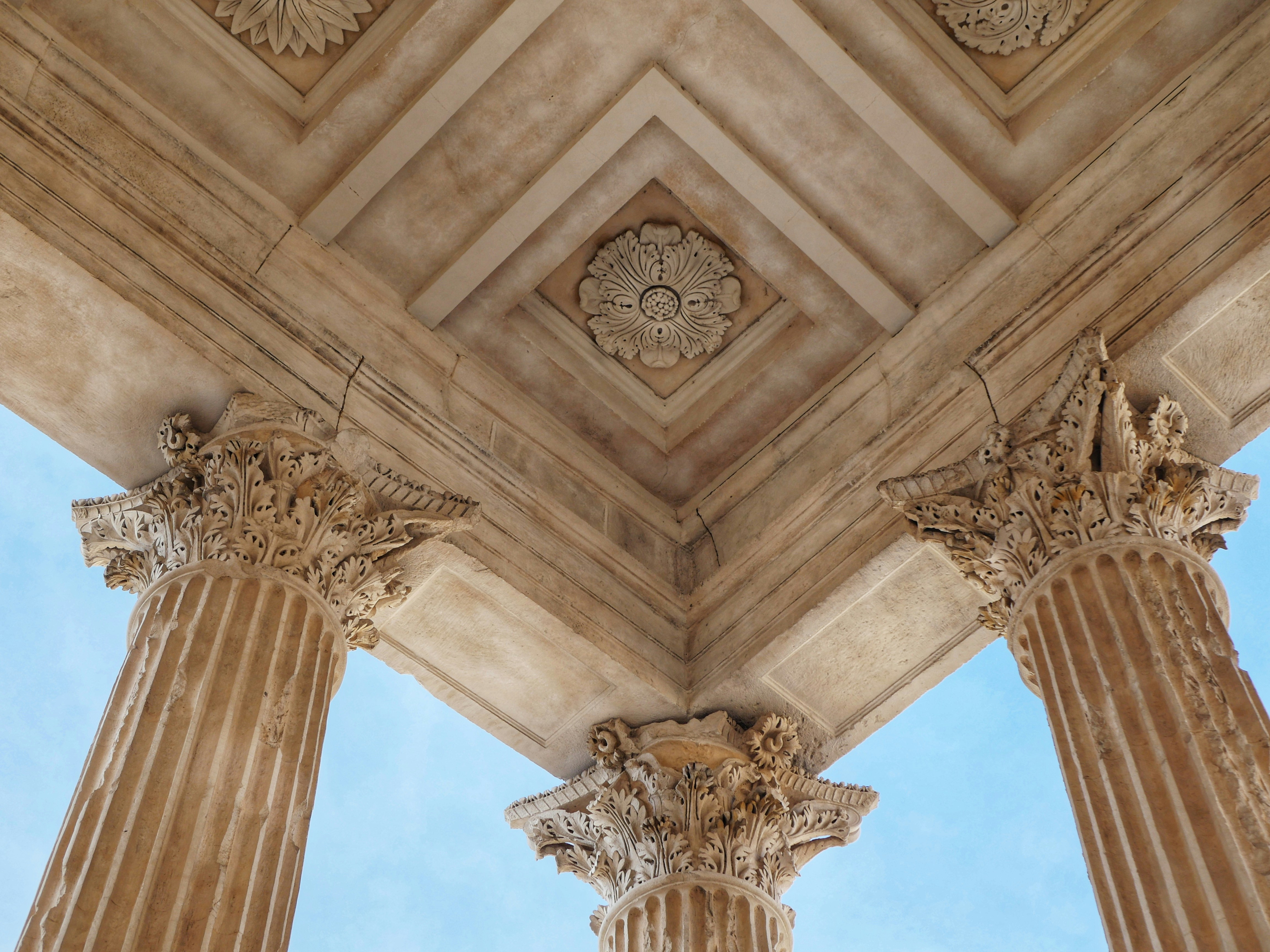 Symmetry Under Stone Canopy: Carved Capitals Above the Blue