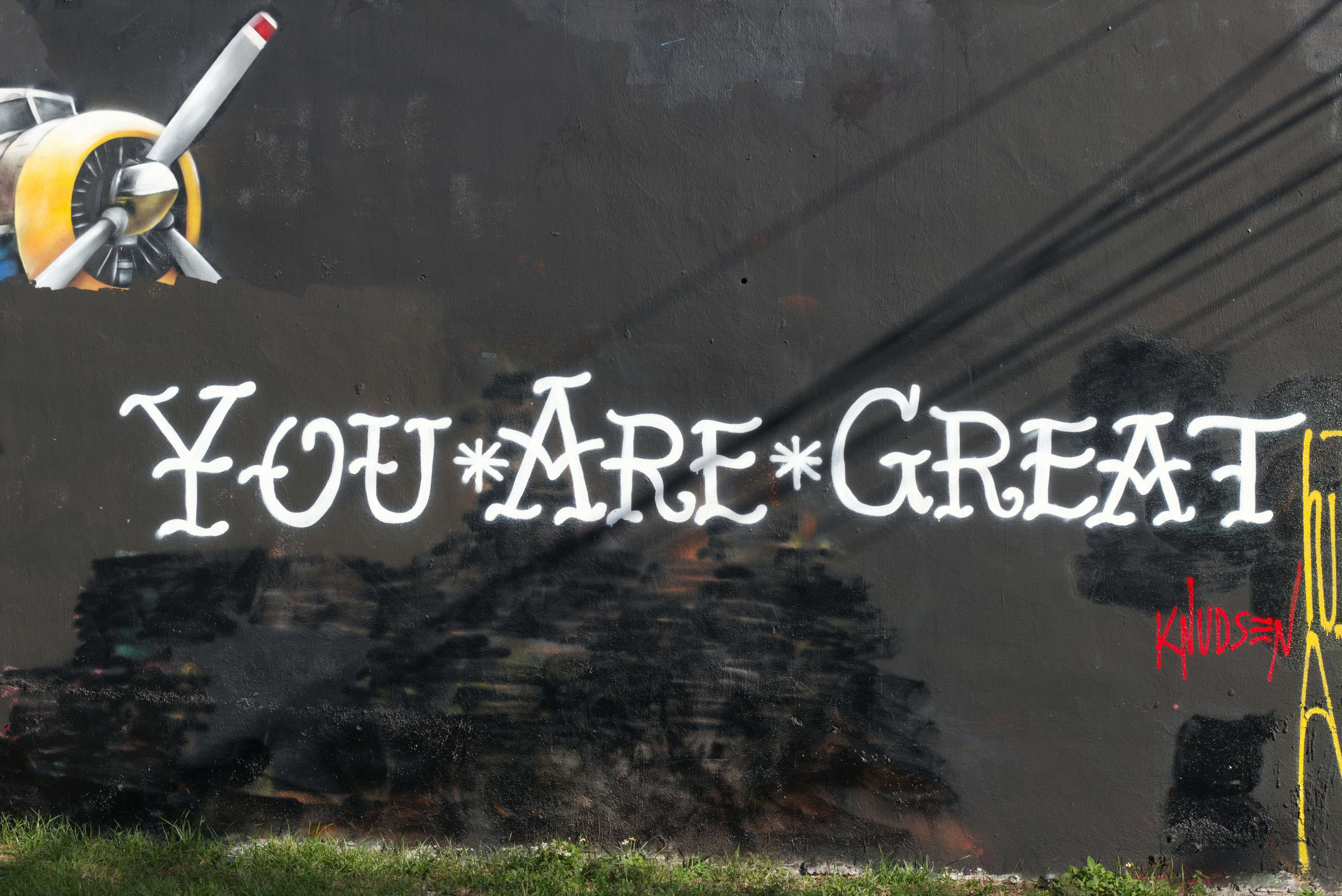 You Are Great: Graffiti Revelry on a Weathered Wall