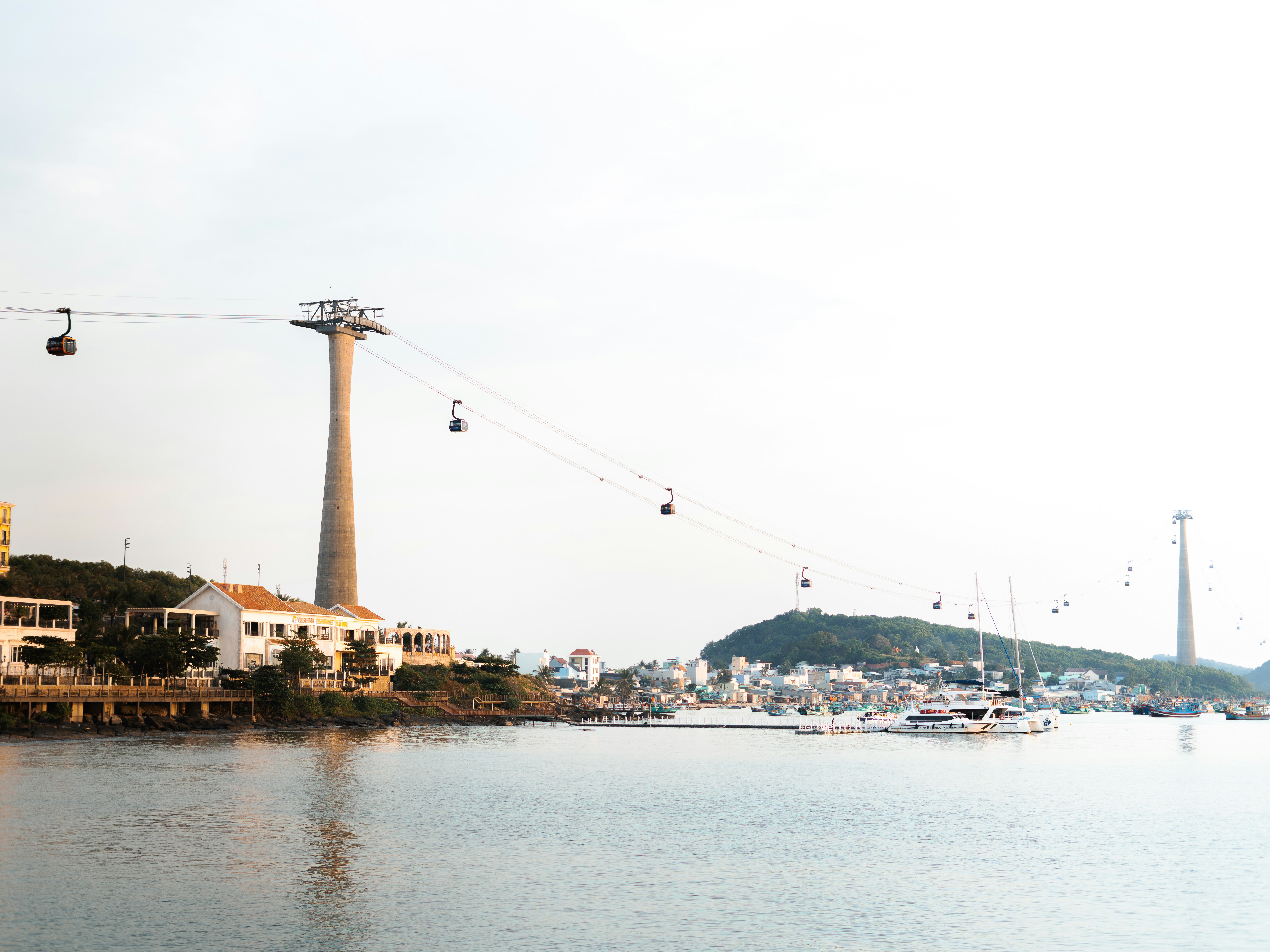 Cable Car over Calm Water: Coastal Village under a Soft Sky