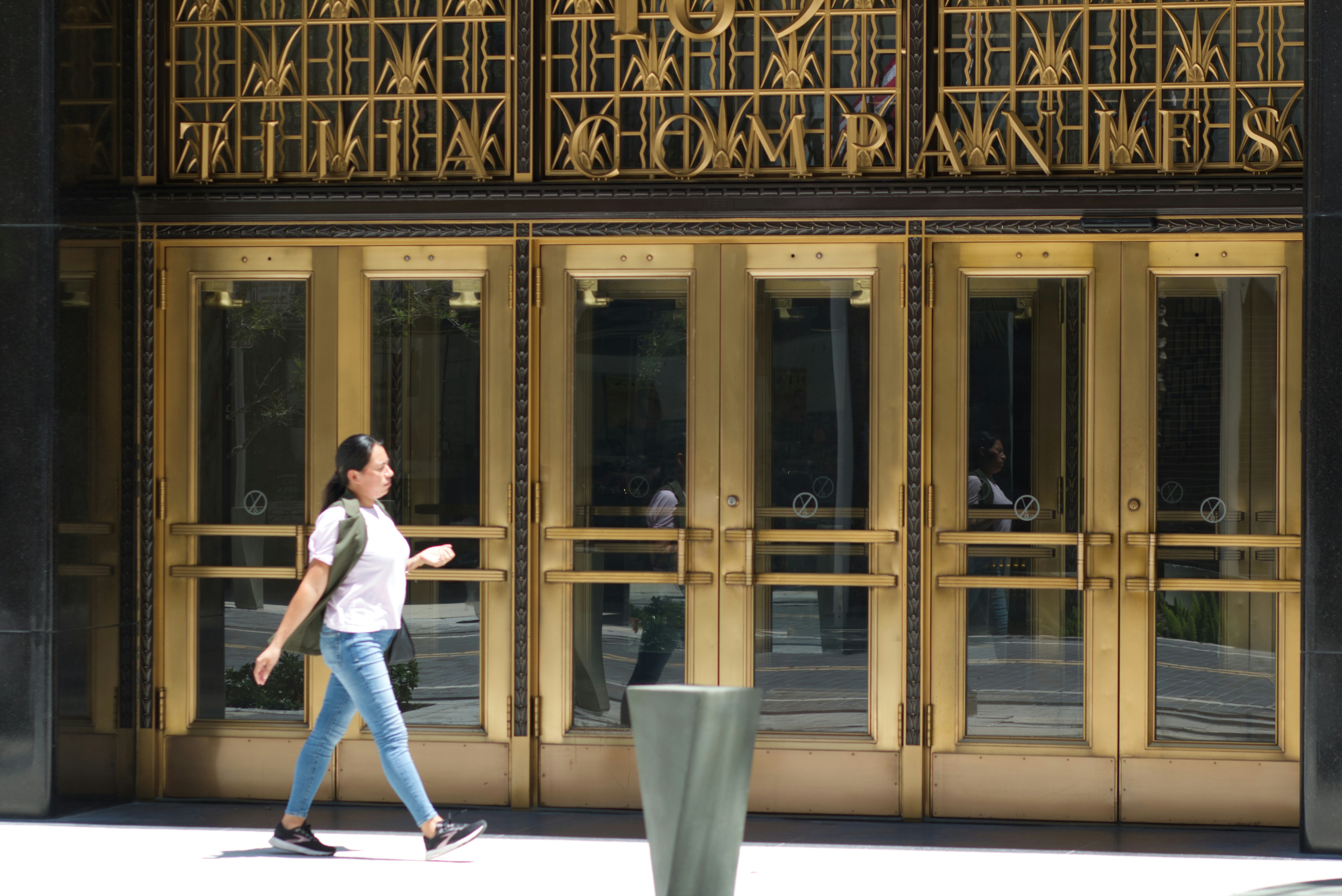Striding Past Gold Doors: A Daylight Moment in the City