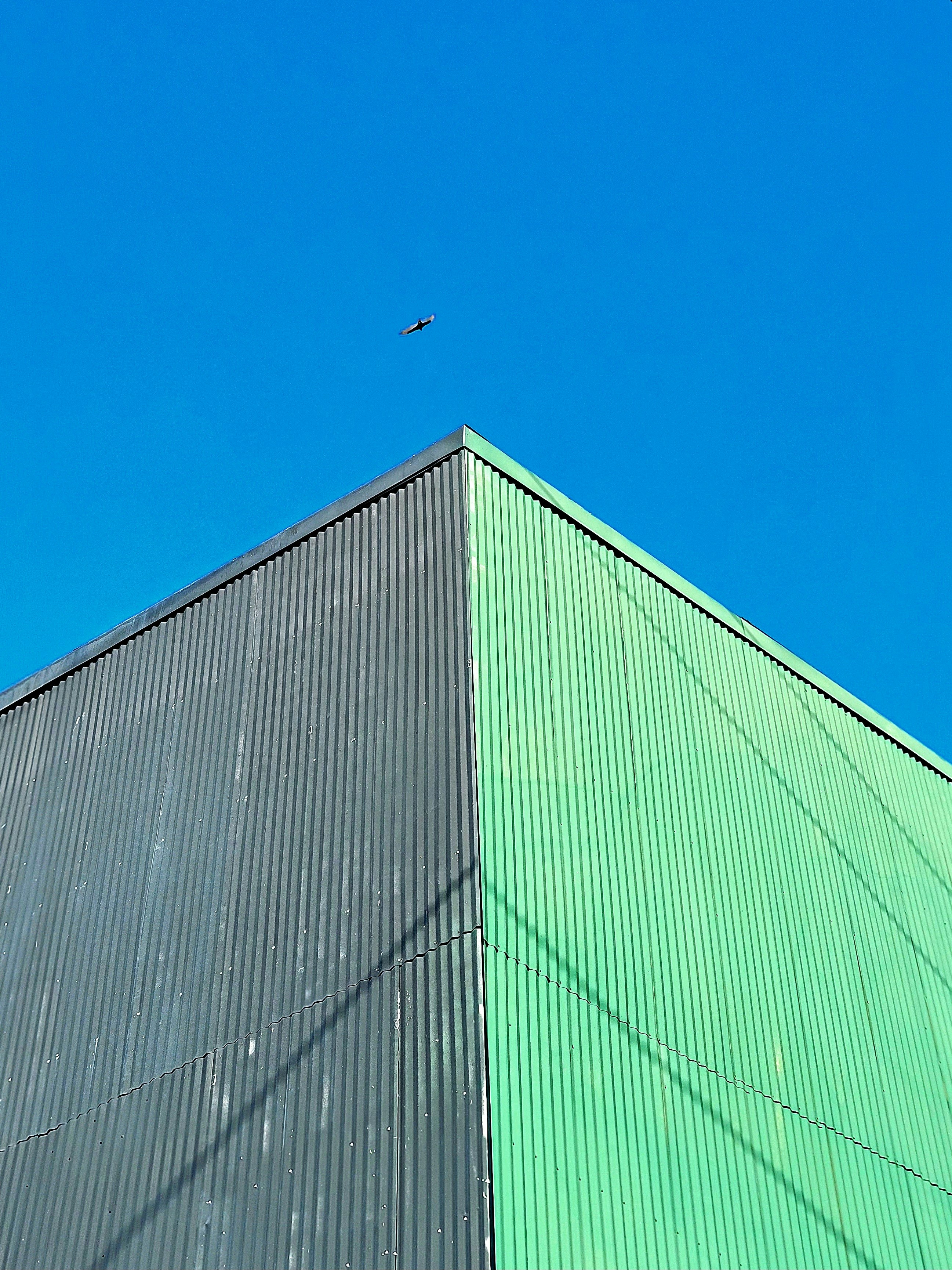 Sharp blue sky over a turquoise and graphite industrial facade