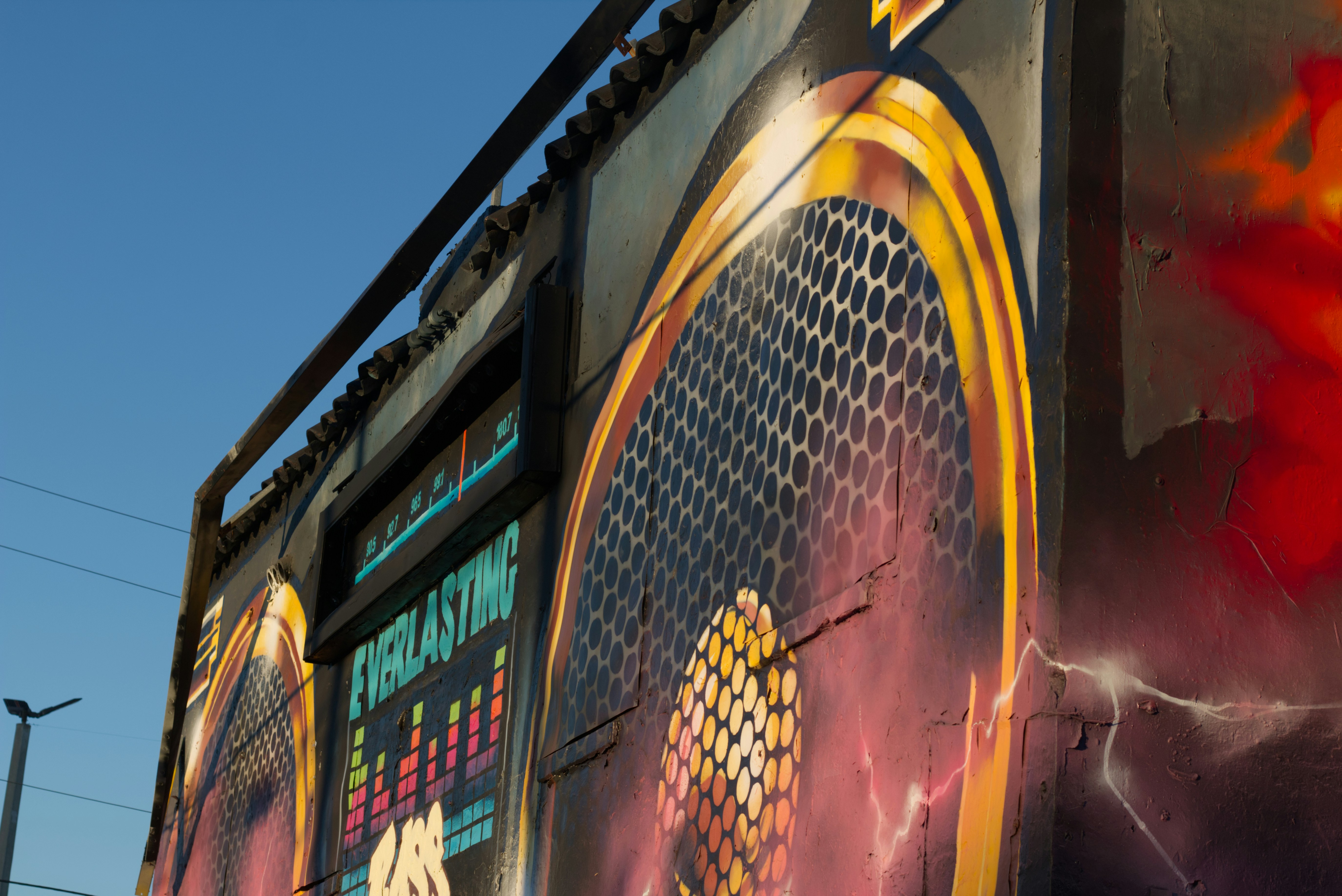 Neon-speckled drumbeat: a mural's electric gaze