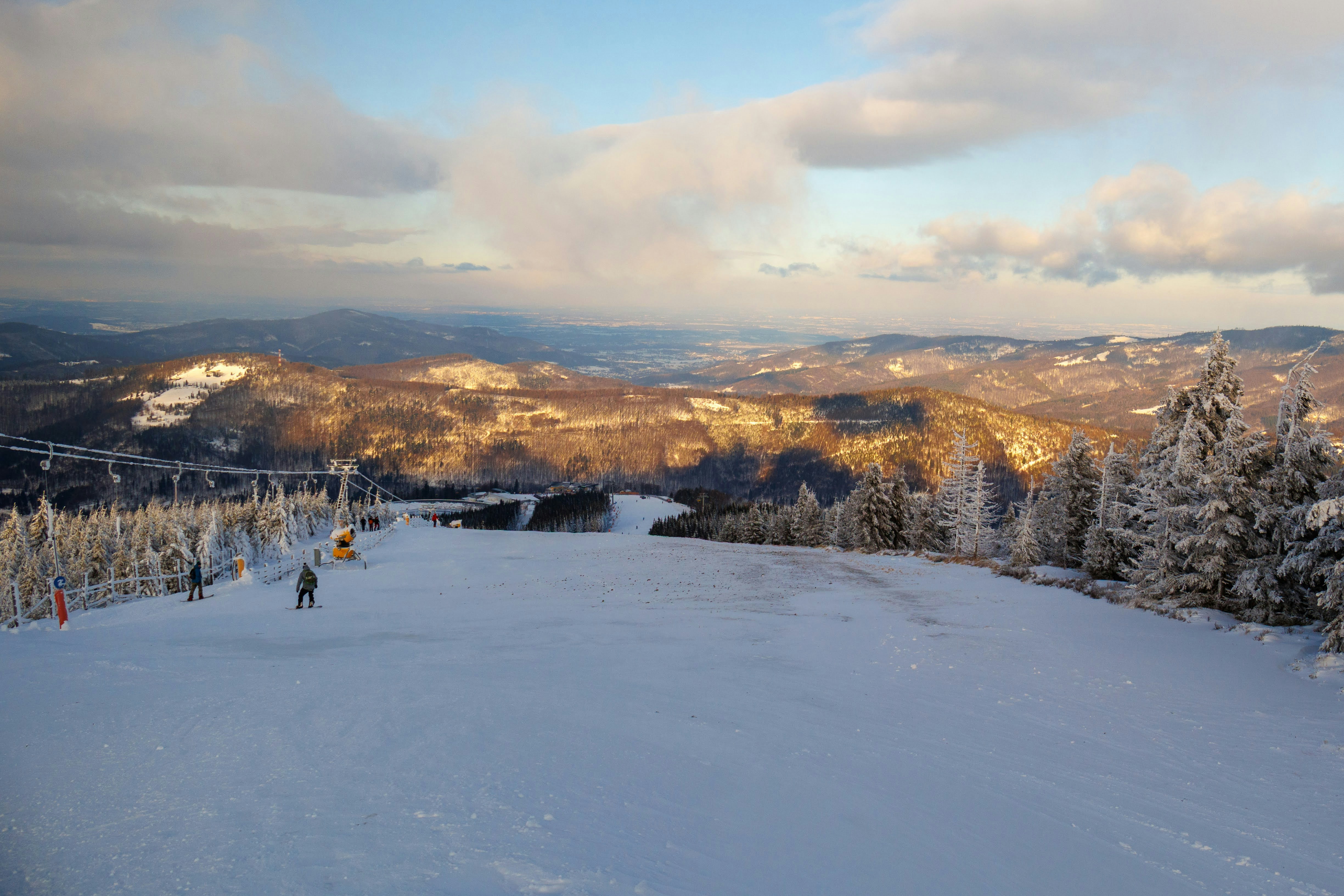 Snow-dusted slopes under a gold-tinted alpine sunrise
