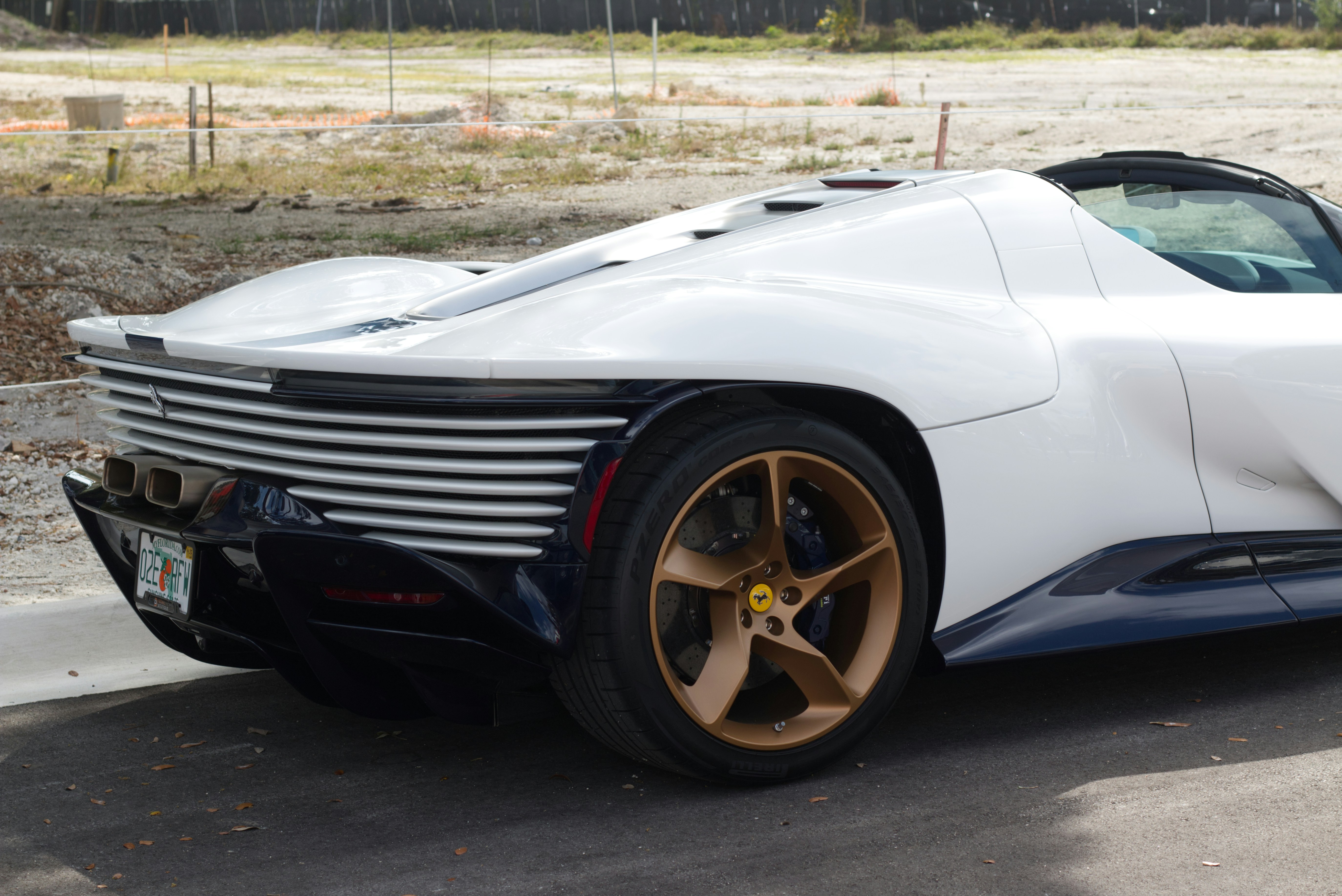 Aggressive white supercar silhouette: gold wheels and vented hood