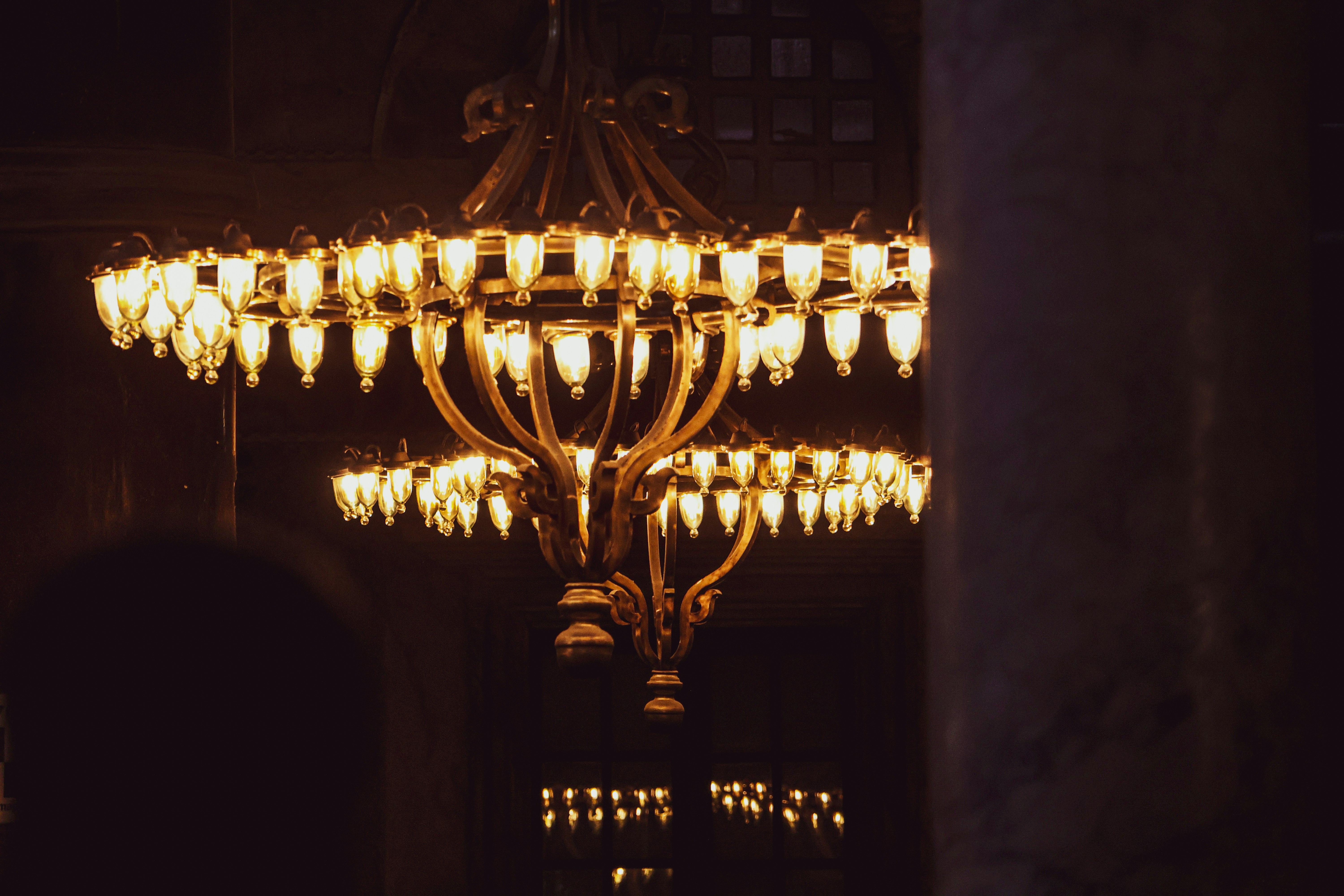 Golden Orbs: An Ornate Chandelier Reflected in Deep Velvet Shadows