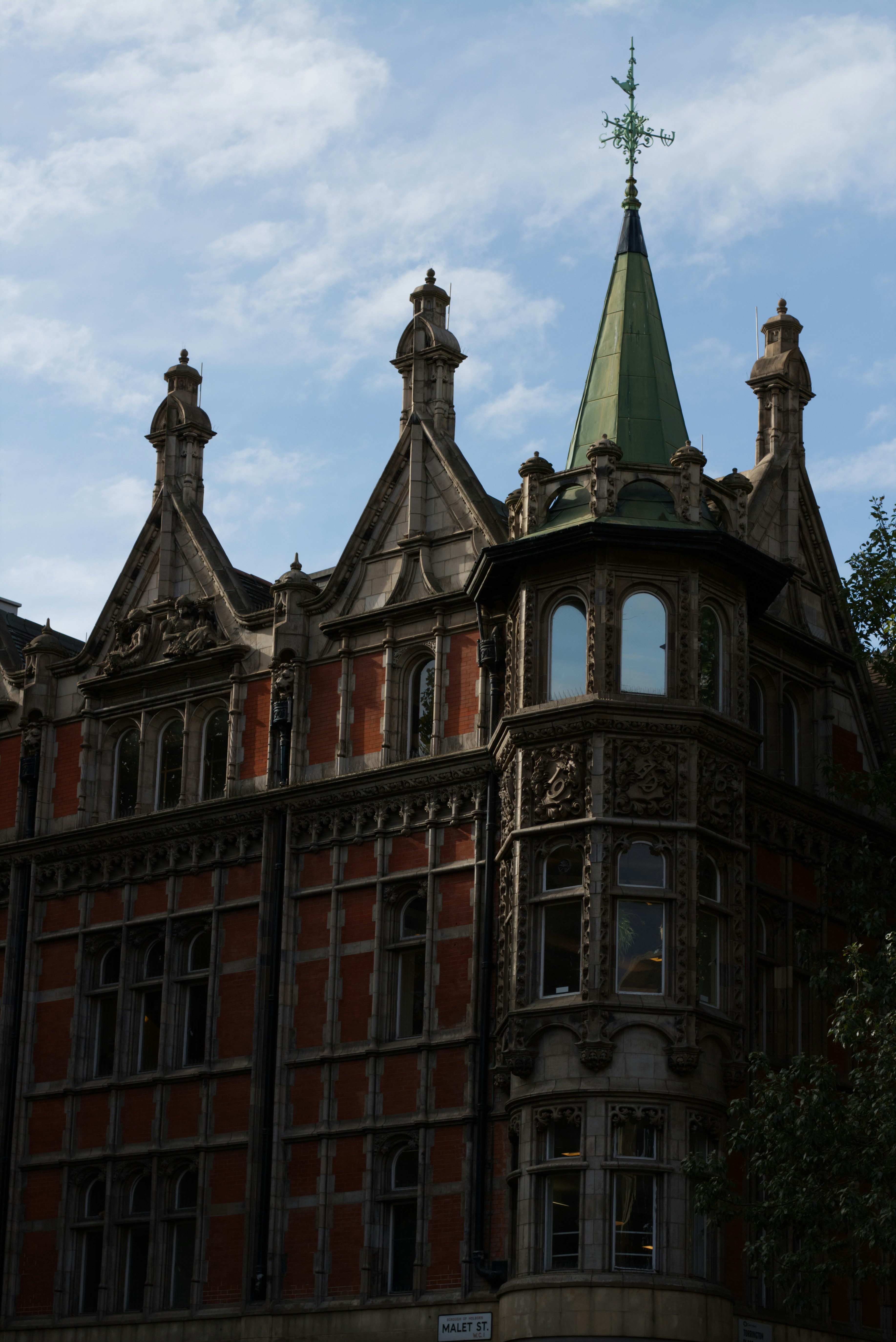 Gothic Facade and Turreted Skyline Above Red Brick Architecture