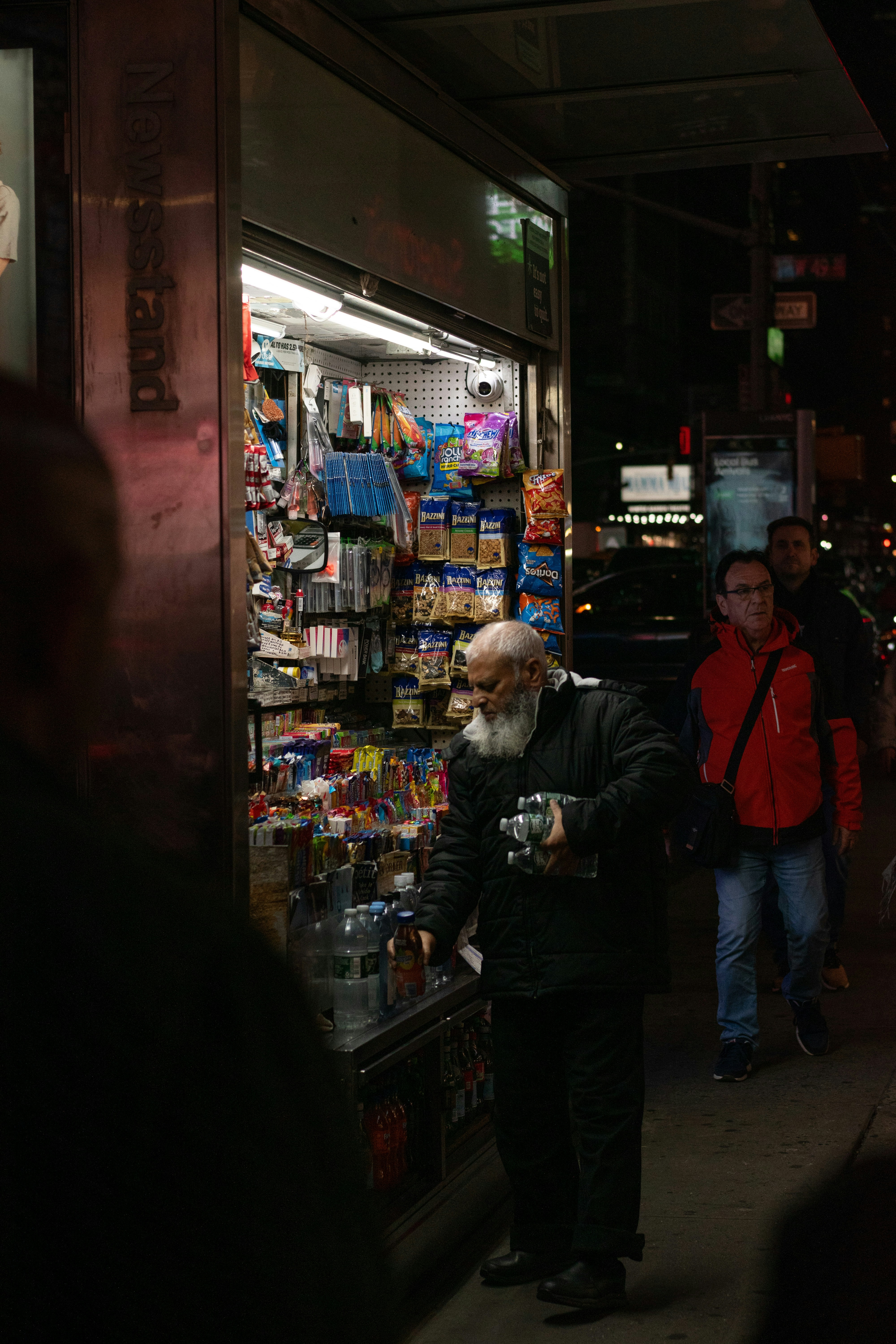 Bearded vendor in a well-lit storefront aisle